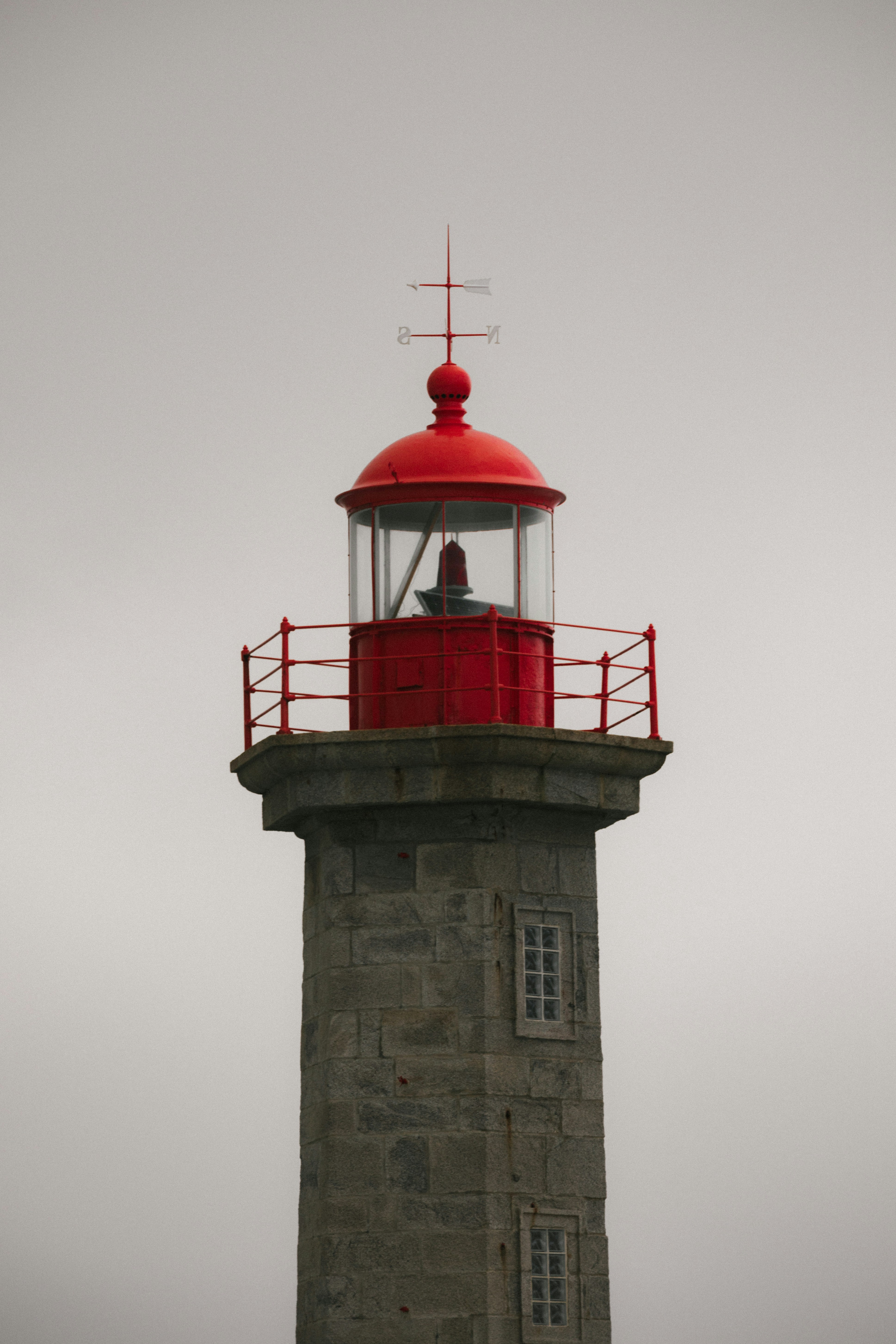 Crimson Lantern Crowned by Mist: A Lighthouse Portrait