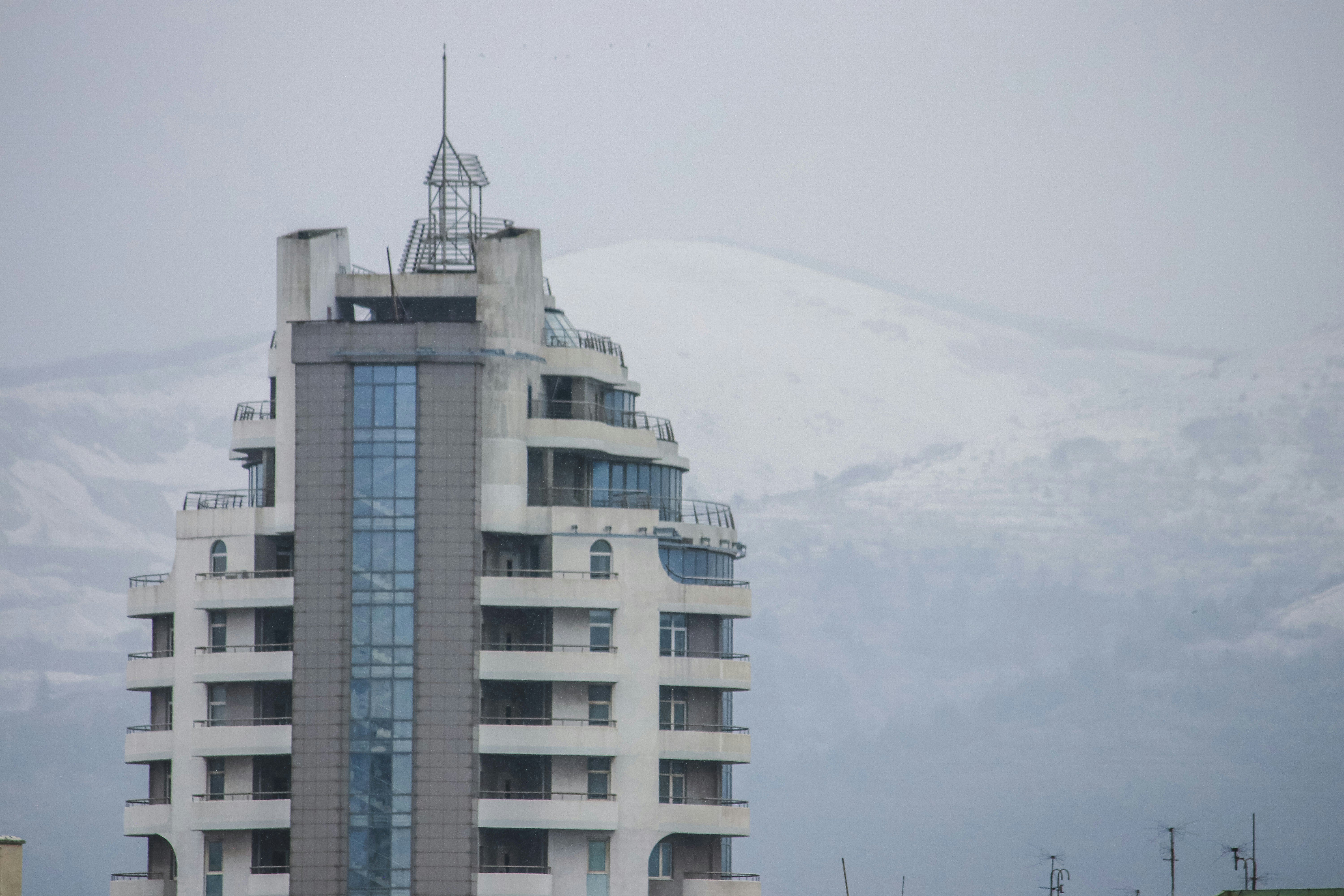 Balconies Beside the White Ridge: A Tower Stands Against Winter Mountains