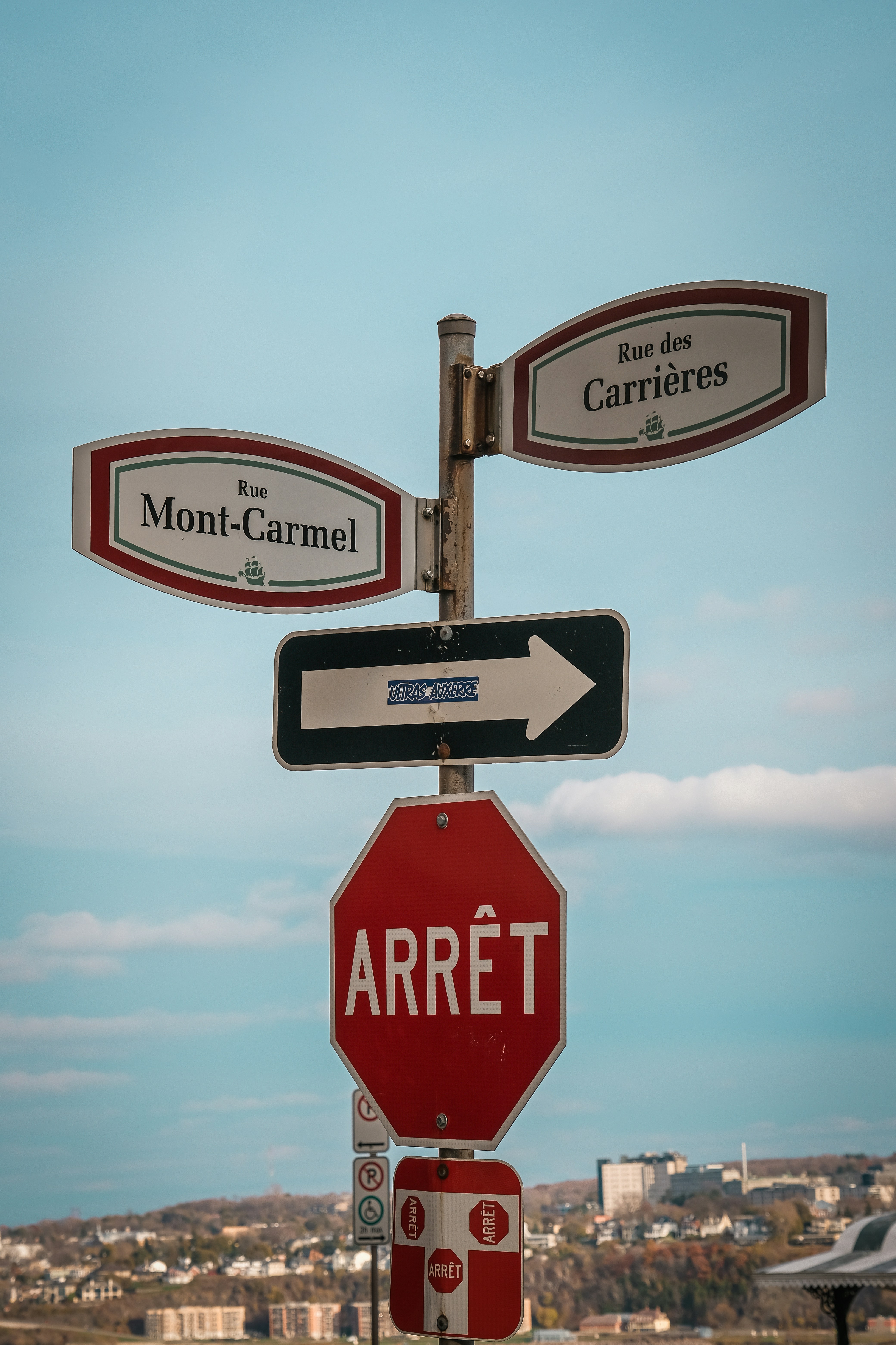 Crossroads in Mont-Carmel: A Stop Sign with Directional Signs