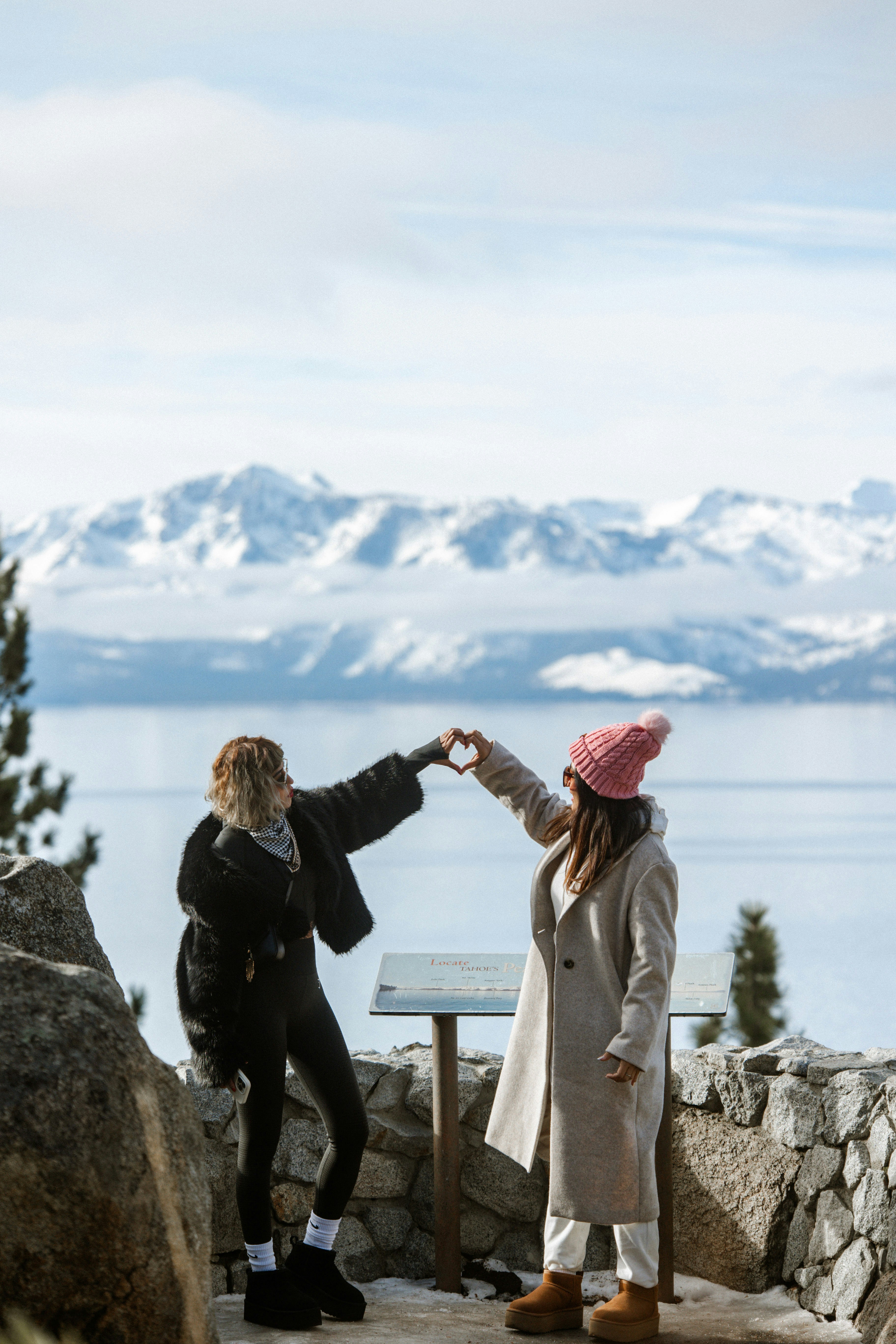 Two Travelers Make a Heart Against the Alpine Horizon