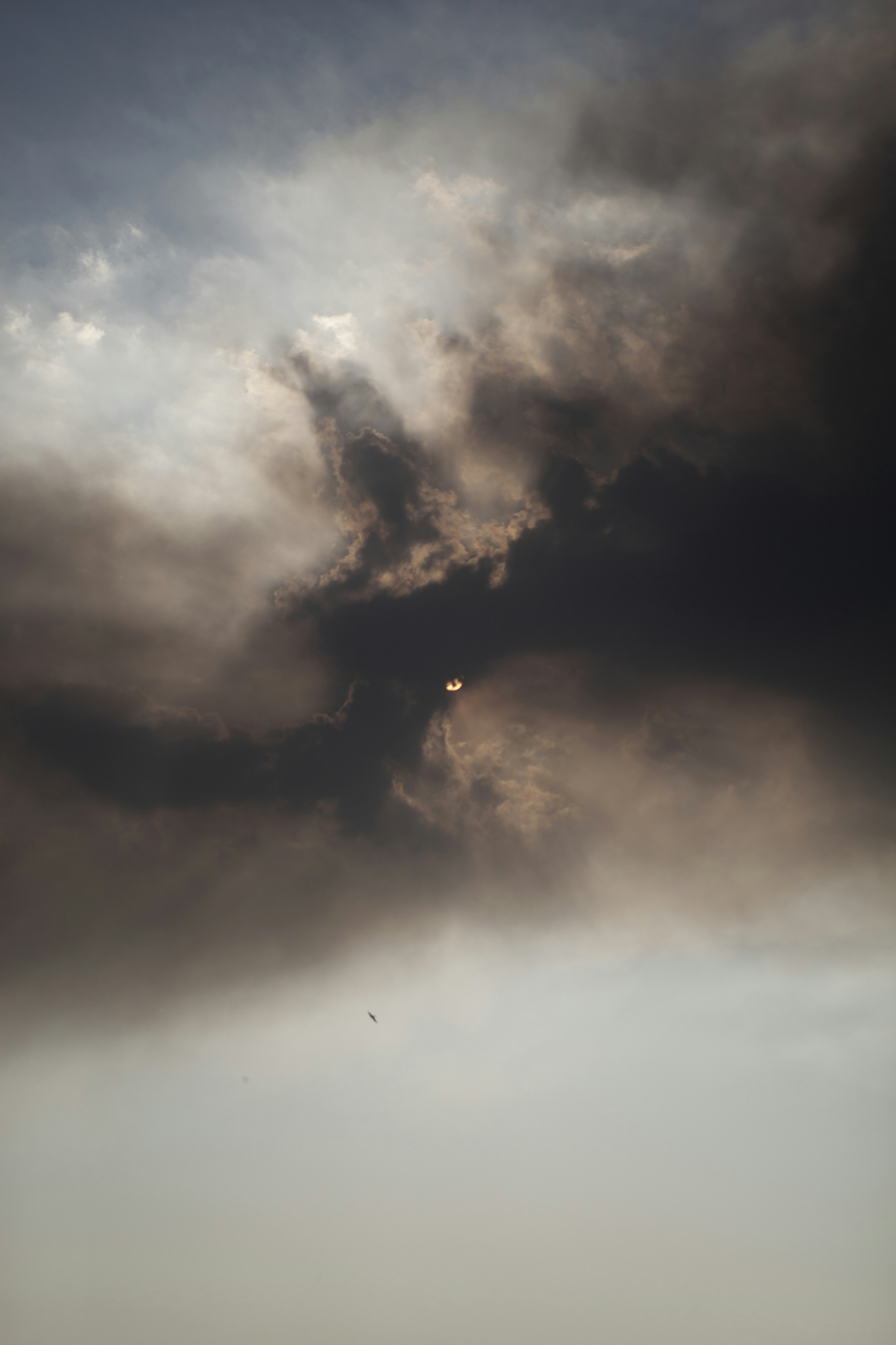 Pale Sun Through Ink-Dark Clouds: A Quiet Break in the Storm