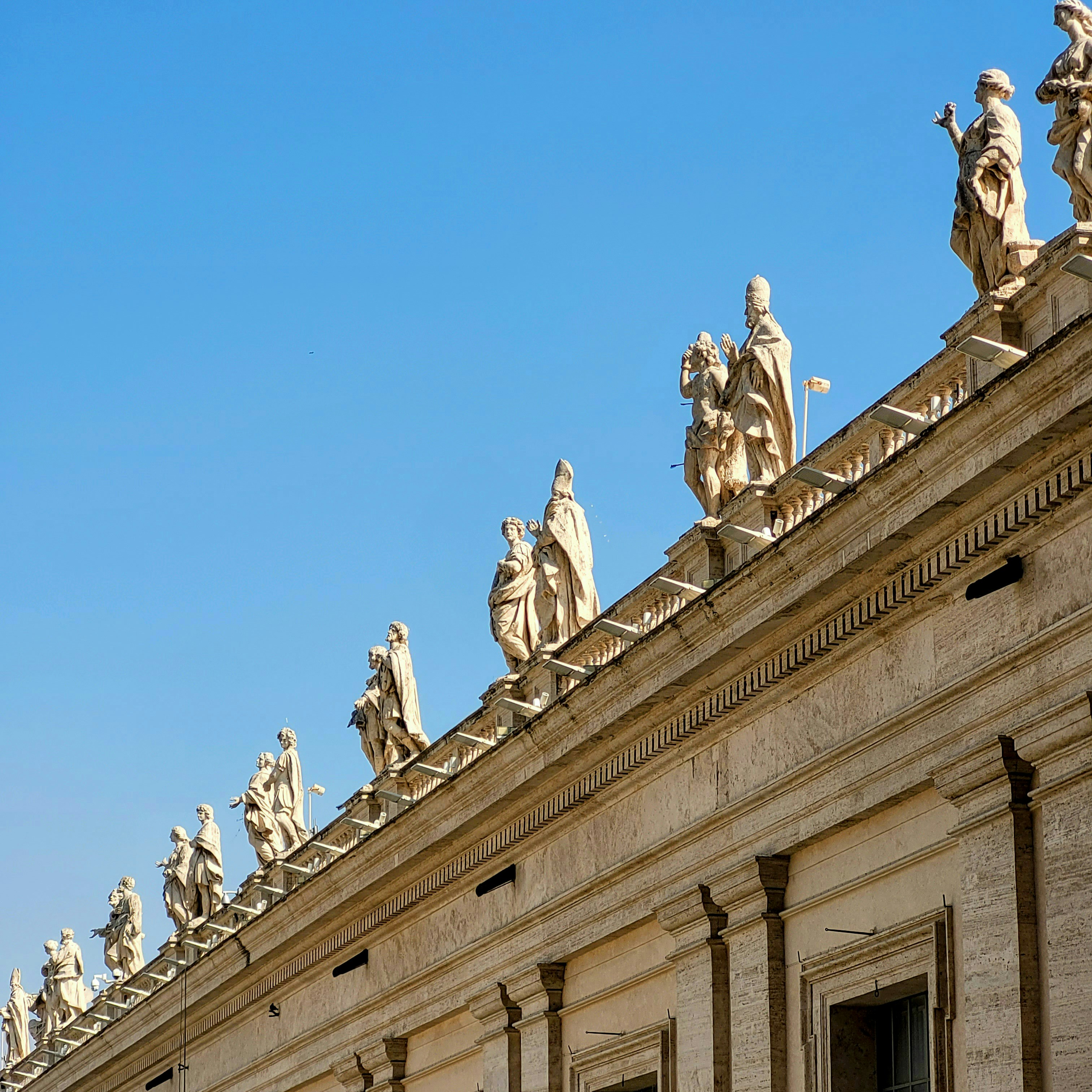 A row of statues on top of a building photo – Free Building Image on ...