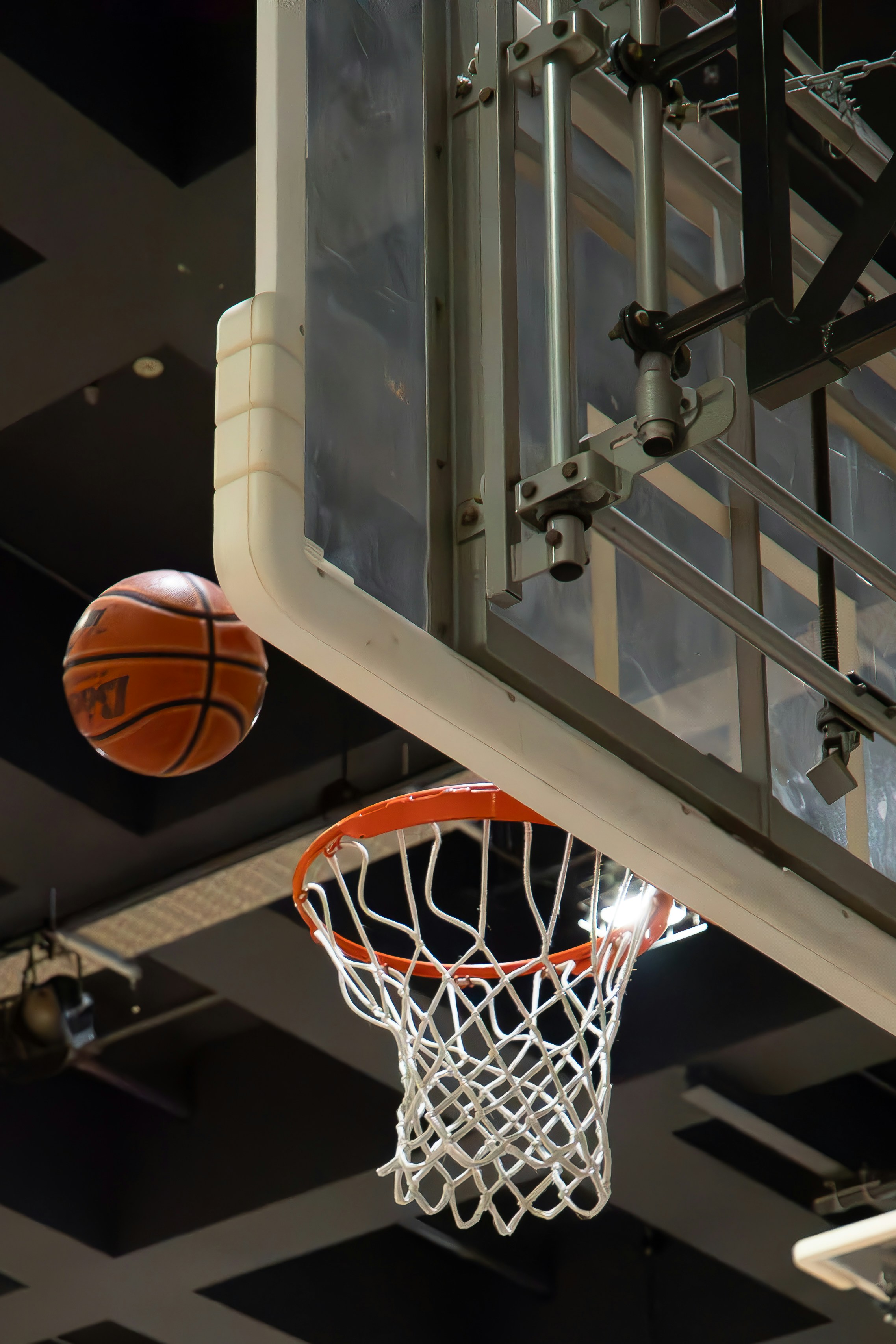Basketball Hoop in Quiet Gym: A Basketball in Flight Near the Backboard