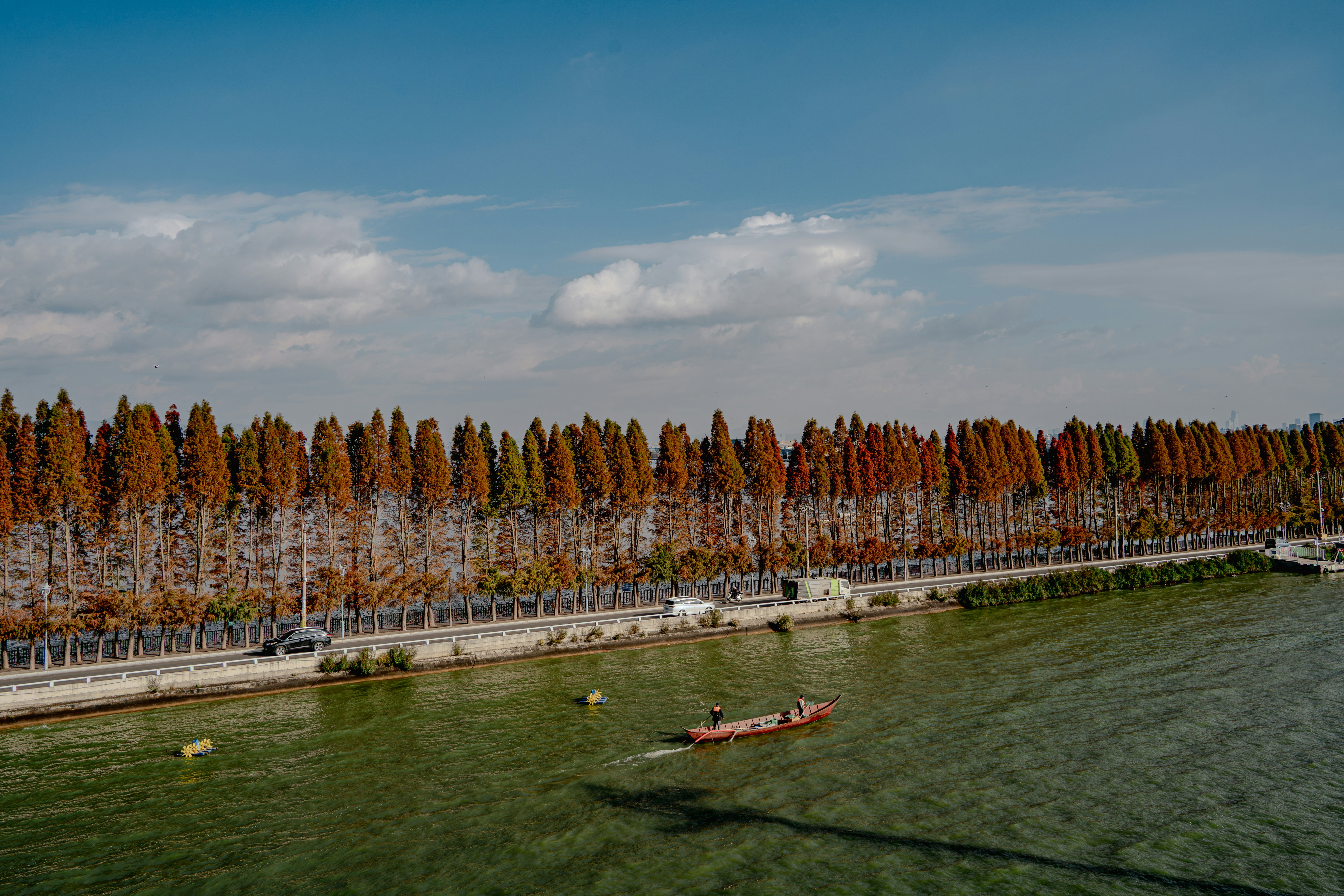 Autumn River Row: A lone boat beneath copper-tinted treelines