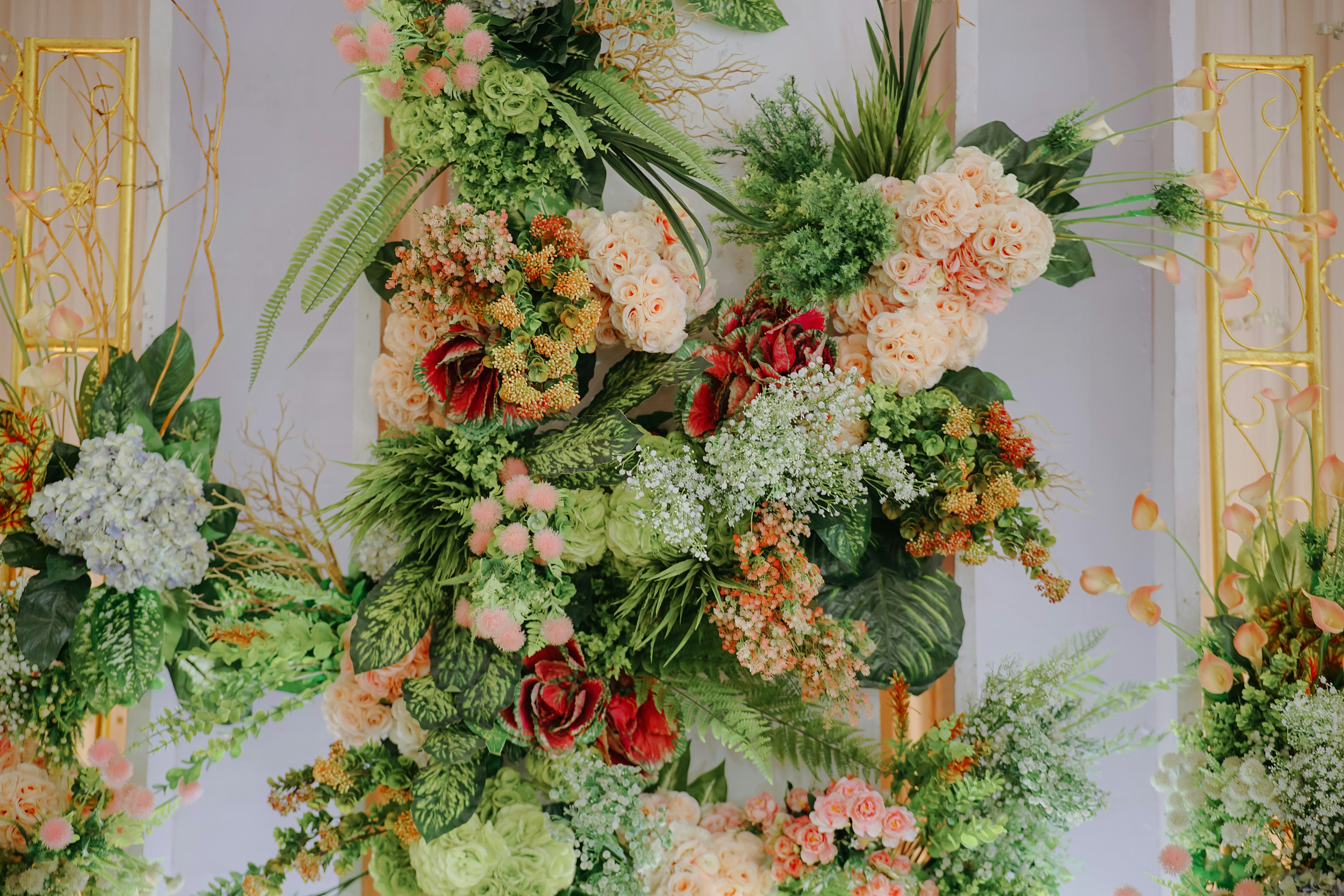 Blooming Ceremony: A Cascade of Peonies and Roses Framed by Golden Arches