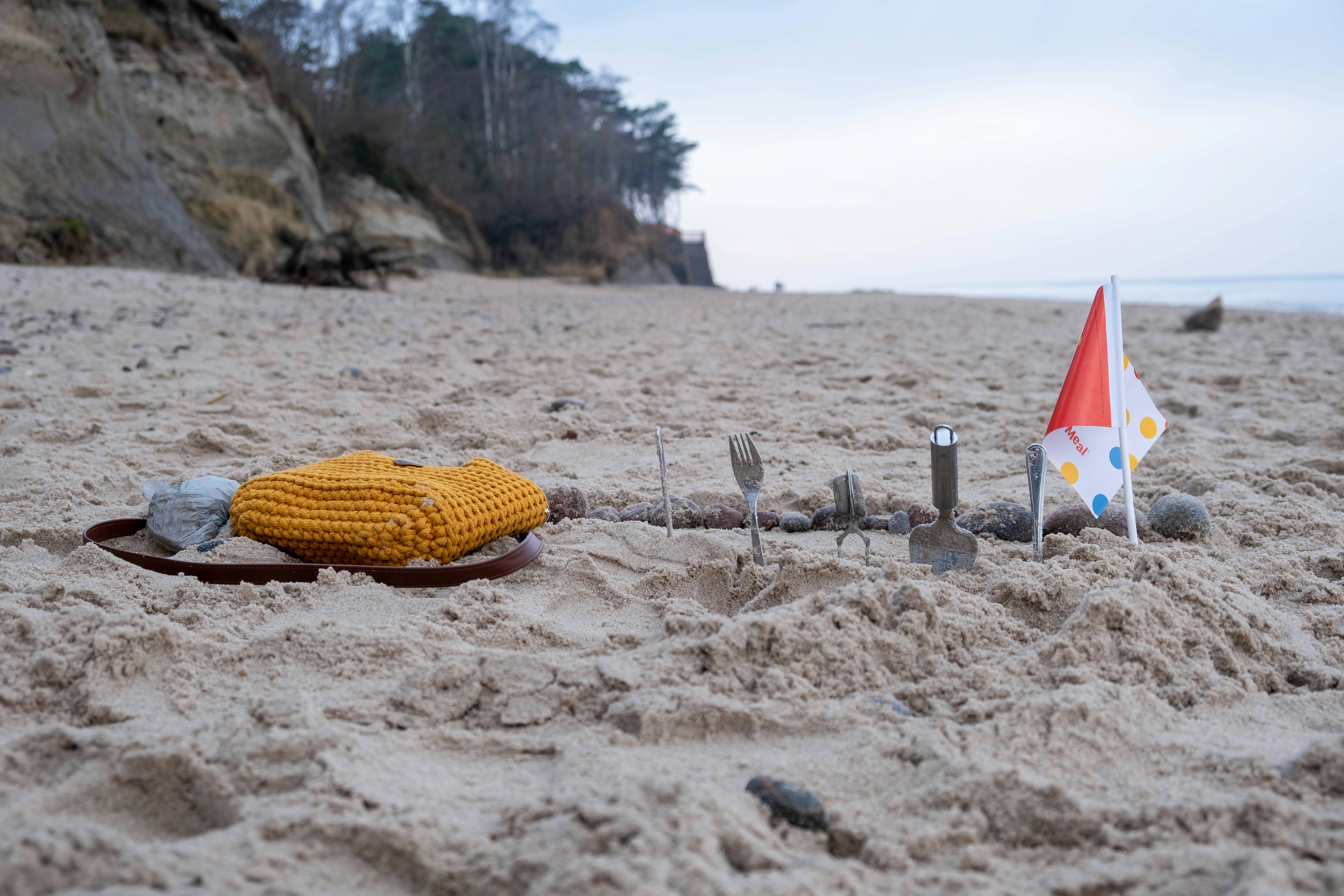 Miniature Beach Picnic: Corn Pillow, Silverware, and a Flag Beside the Dunes