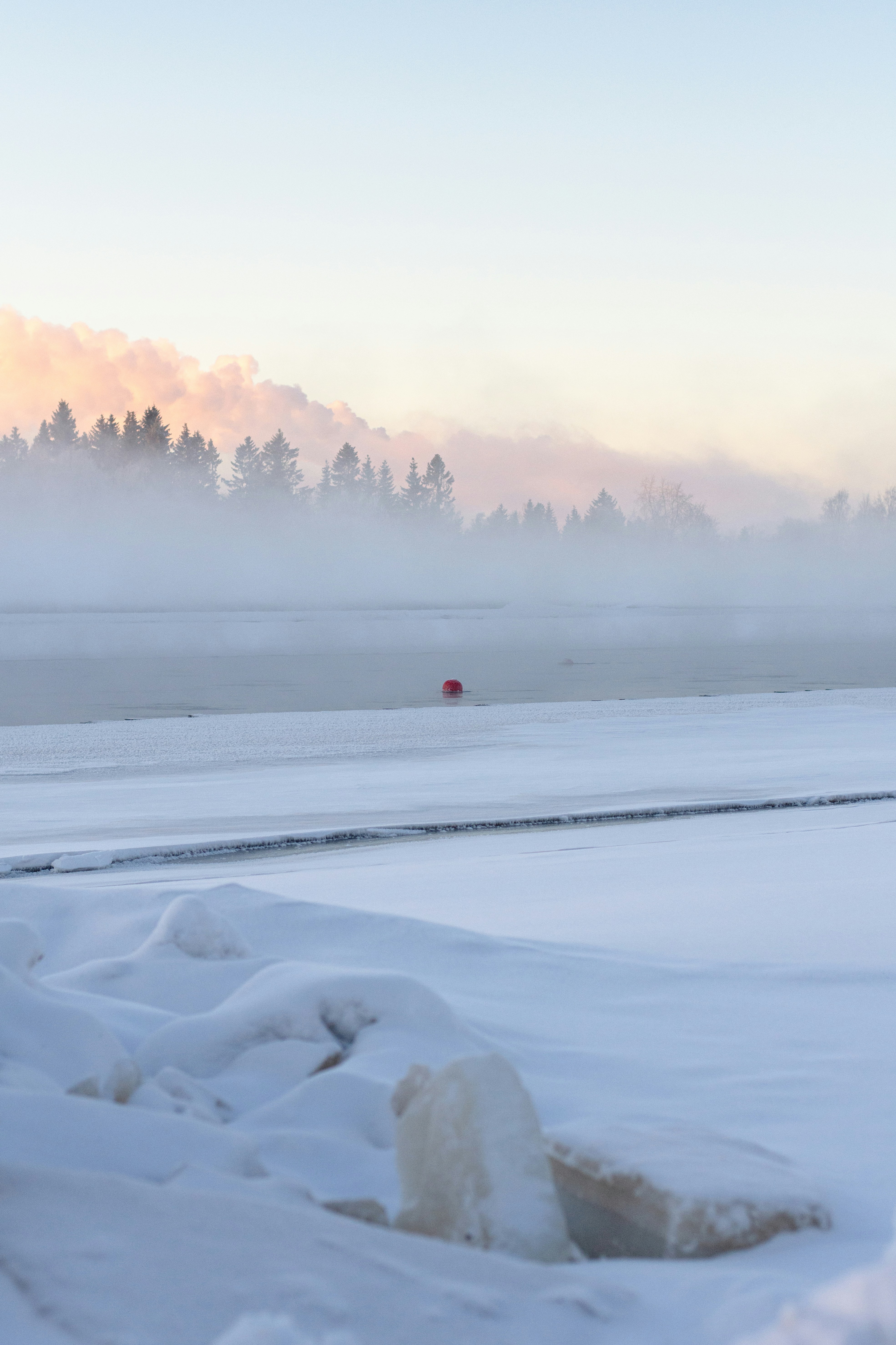 Red Buoy in a Quiet Winter Mist Over a Snowbound Lake
