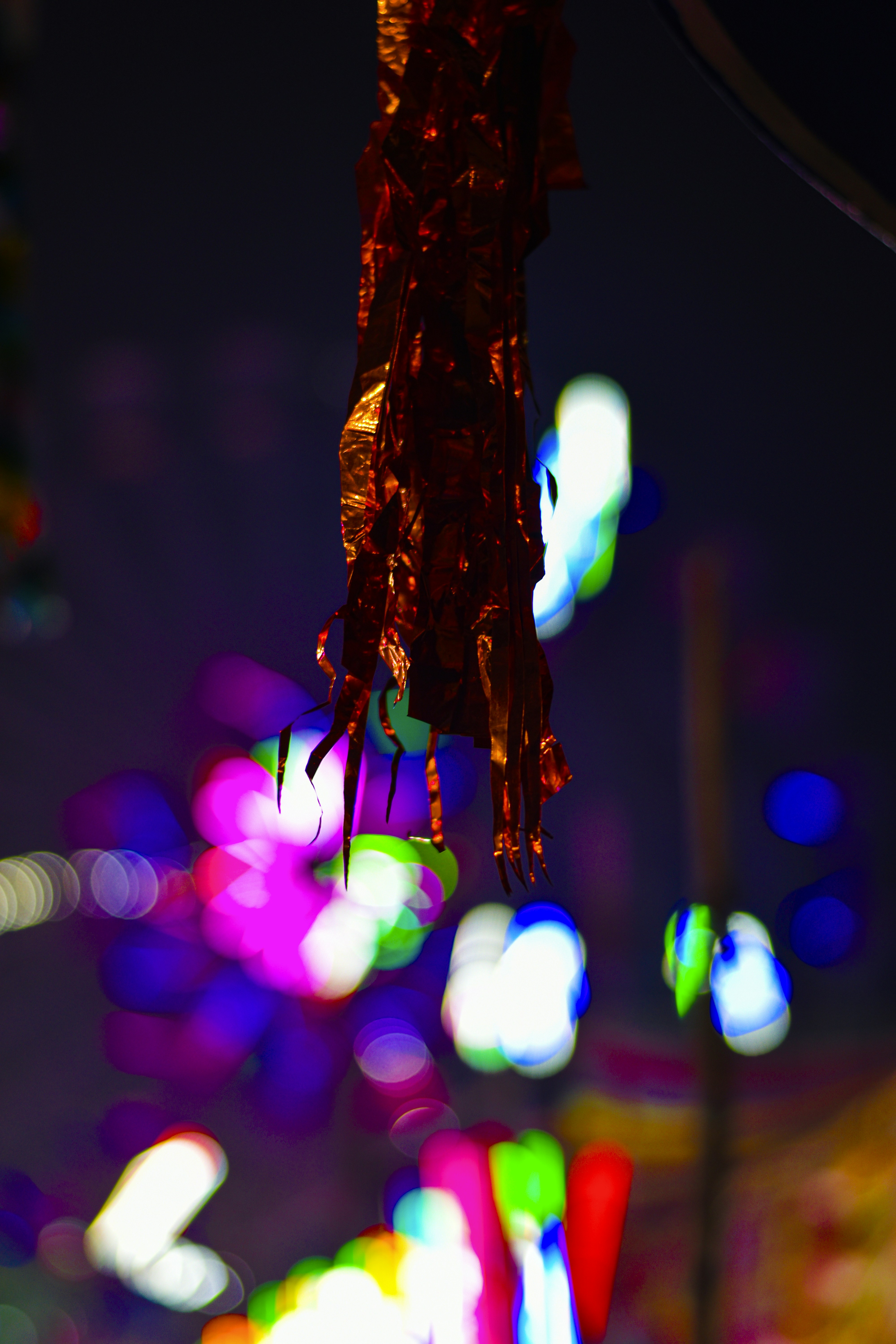 Crimson Foil Threads Against Neon Night Bokeh