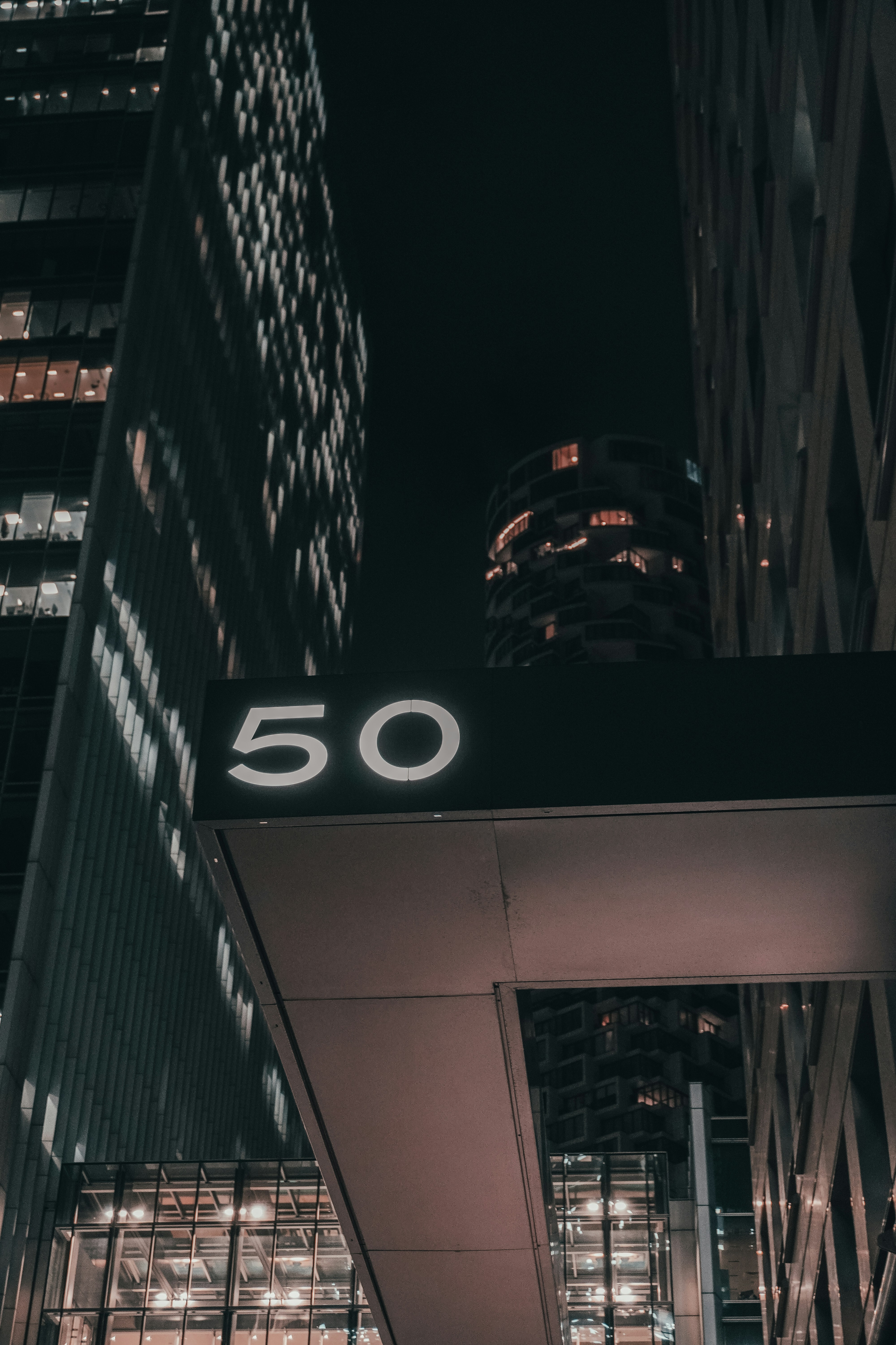The 50 Overhang: Night Geometry Between Glass Giants