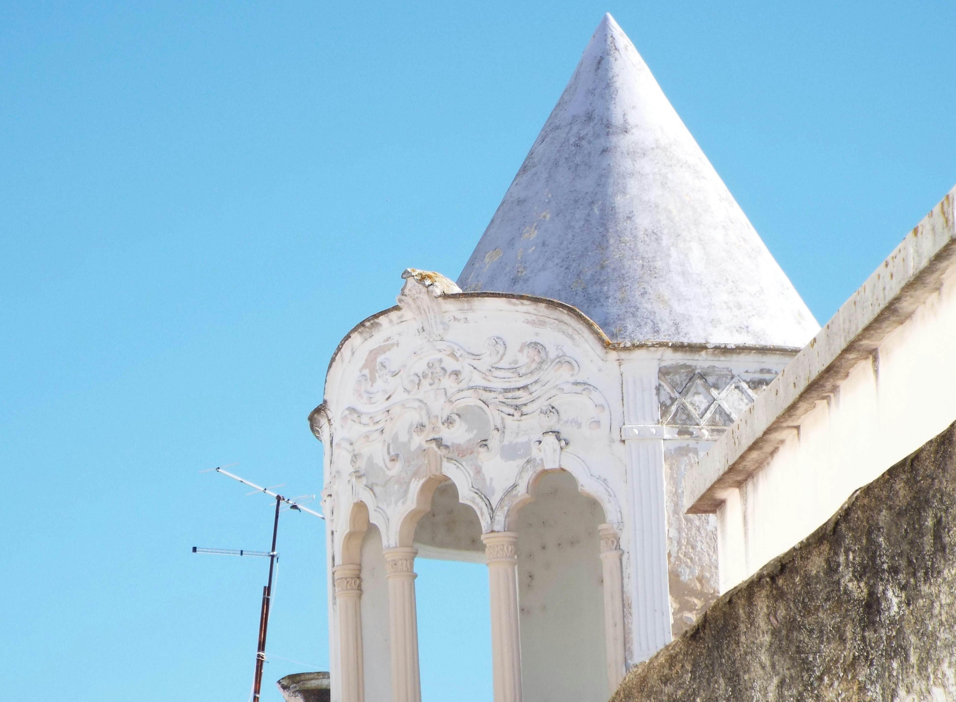 Sunlit Carved Archway Beneath a Cone-Topped Turret