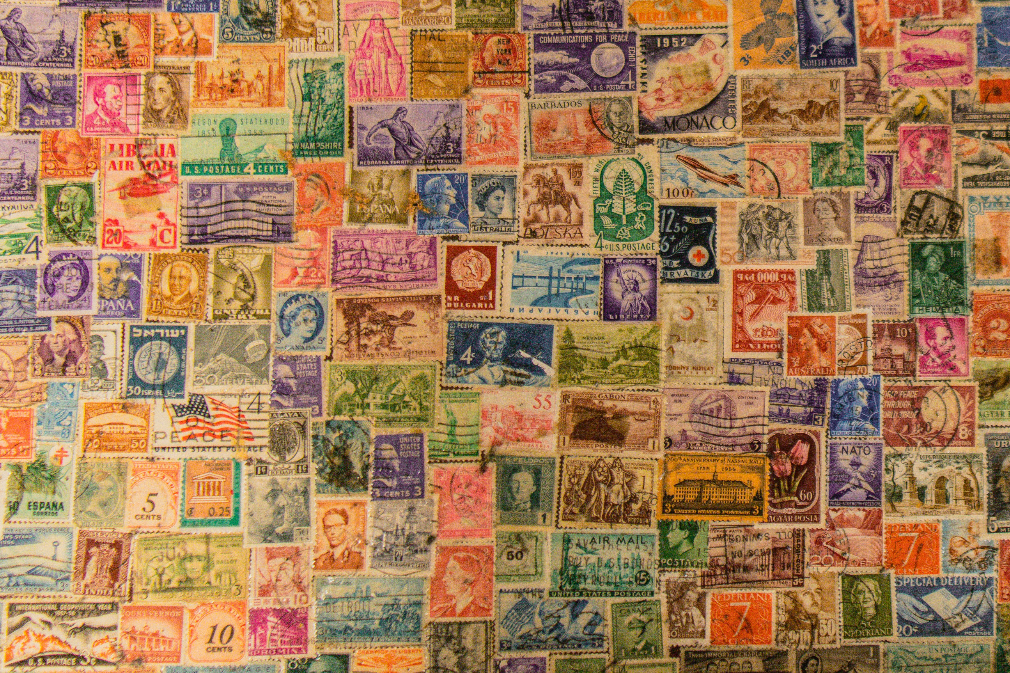 A wall covered in lots of different colored stamps photo – Free Postage ...