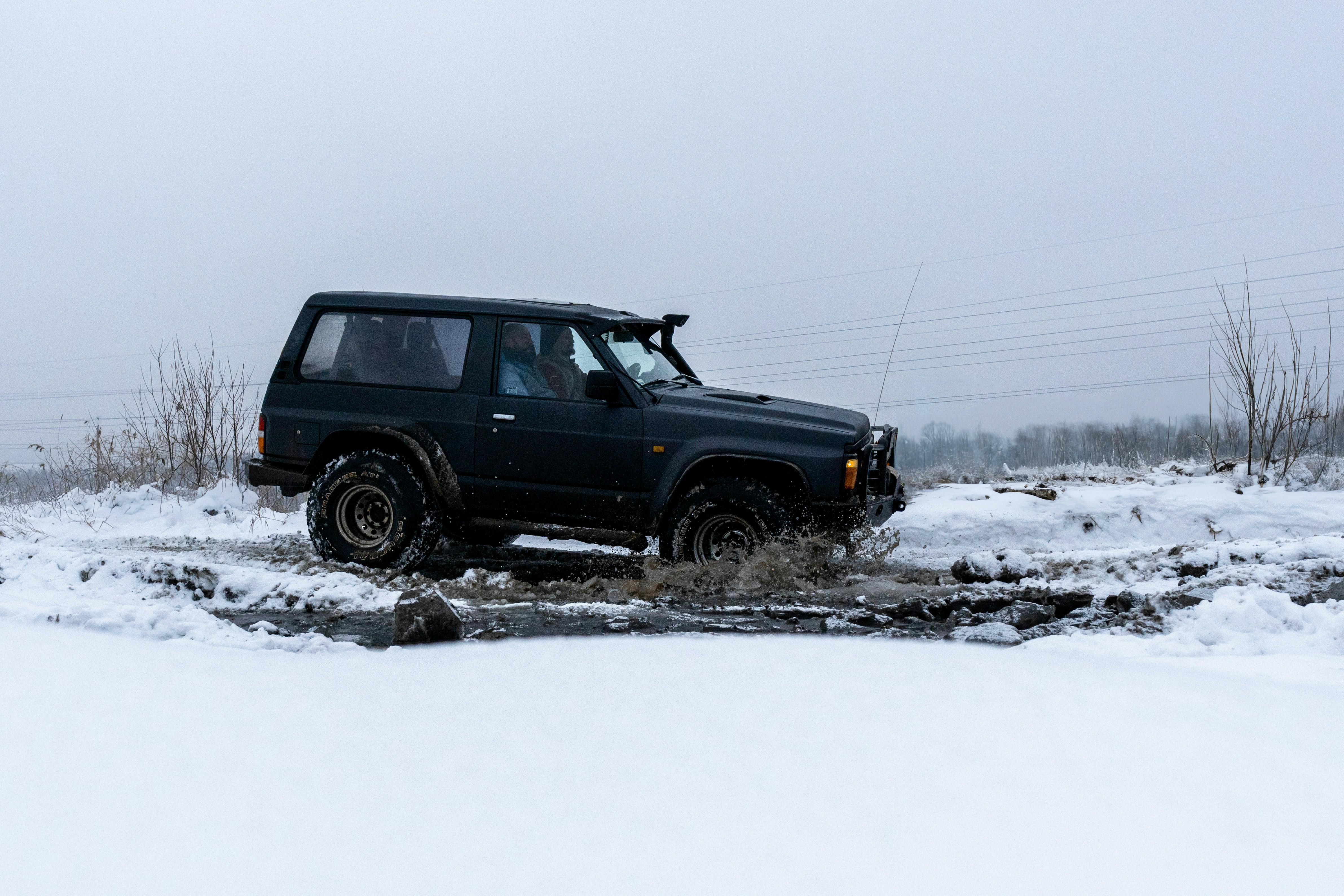 A jeep driving through a puddle in the snow photo – Free Automobile ...