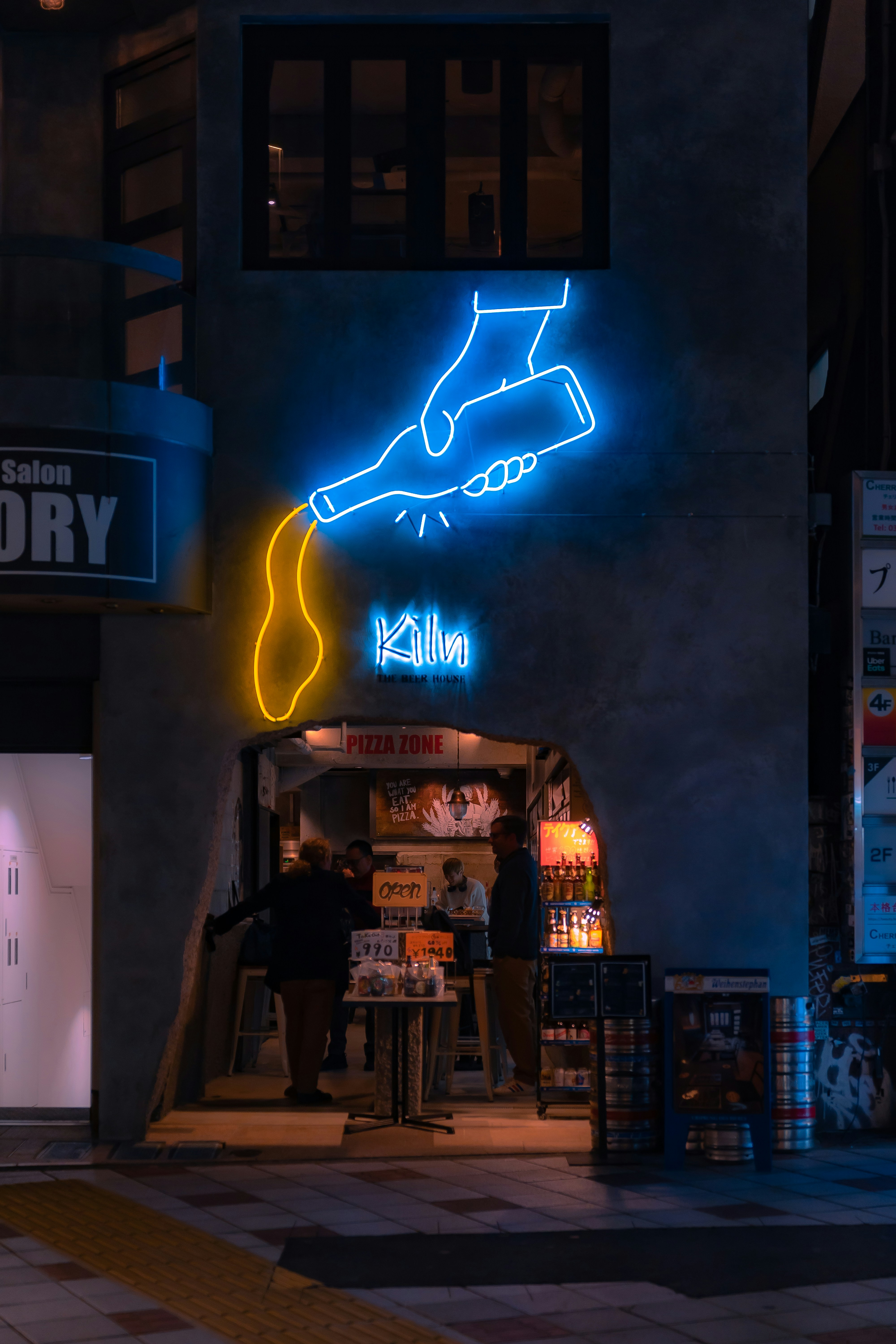 Neon handshake above a cozy pizza corner