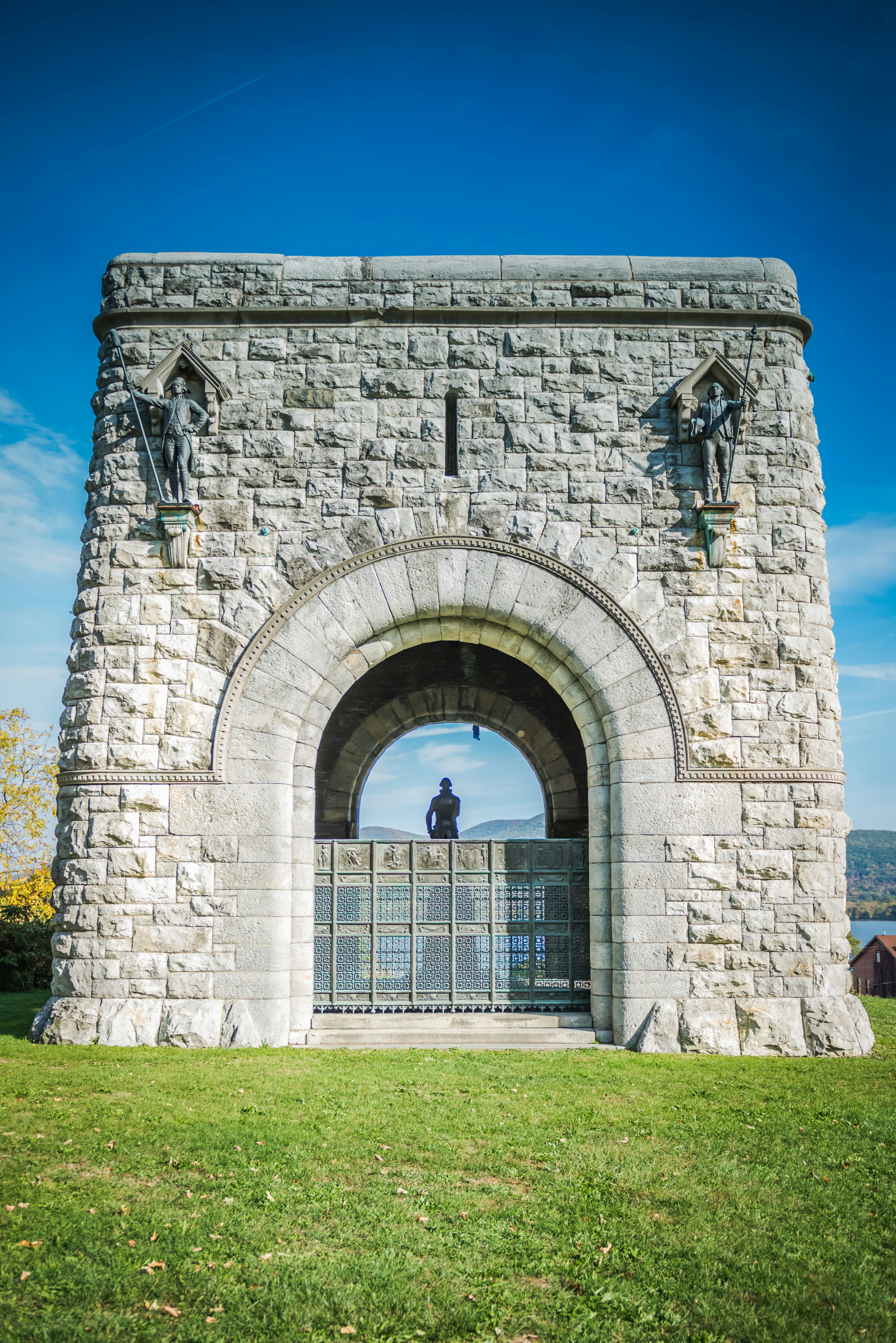 The Archkeeper: Stone Gatehouse Framing a Silent Sentinel
