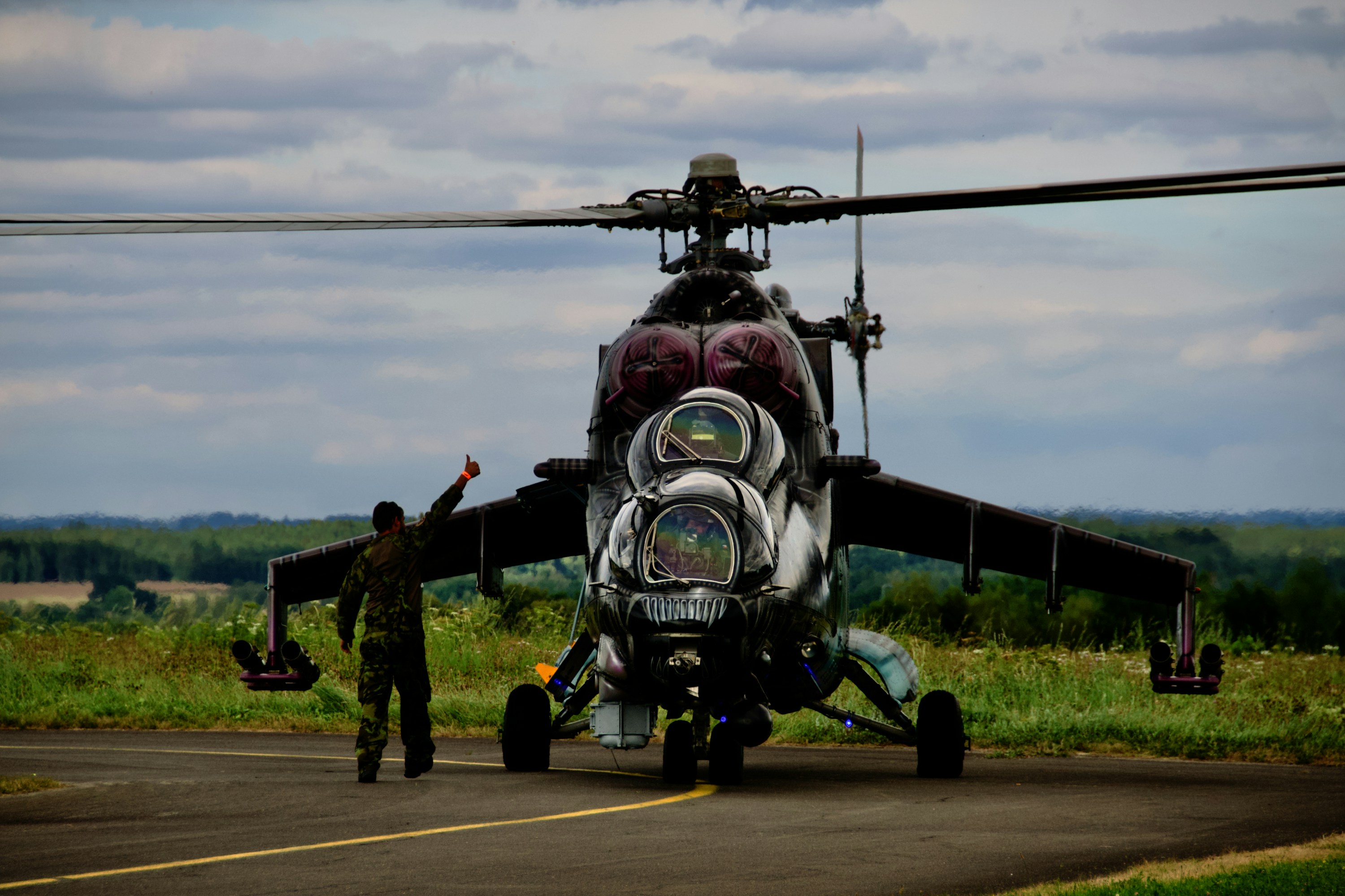A man standing next to a helicopter on a runway photo – Free Letiště ...
