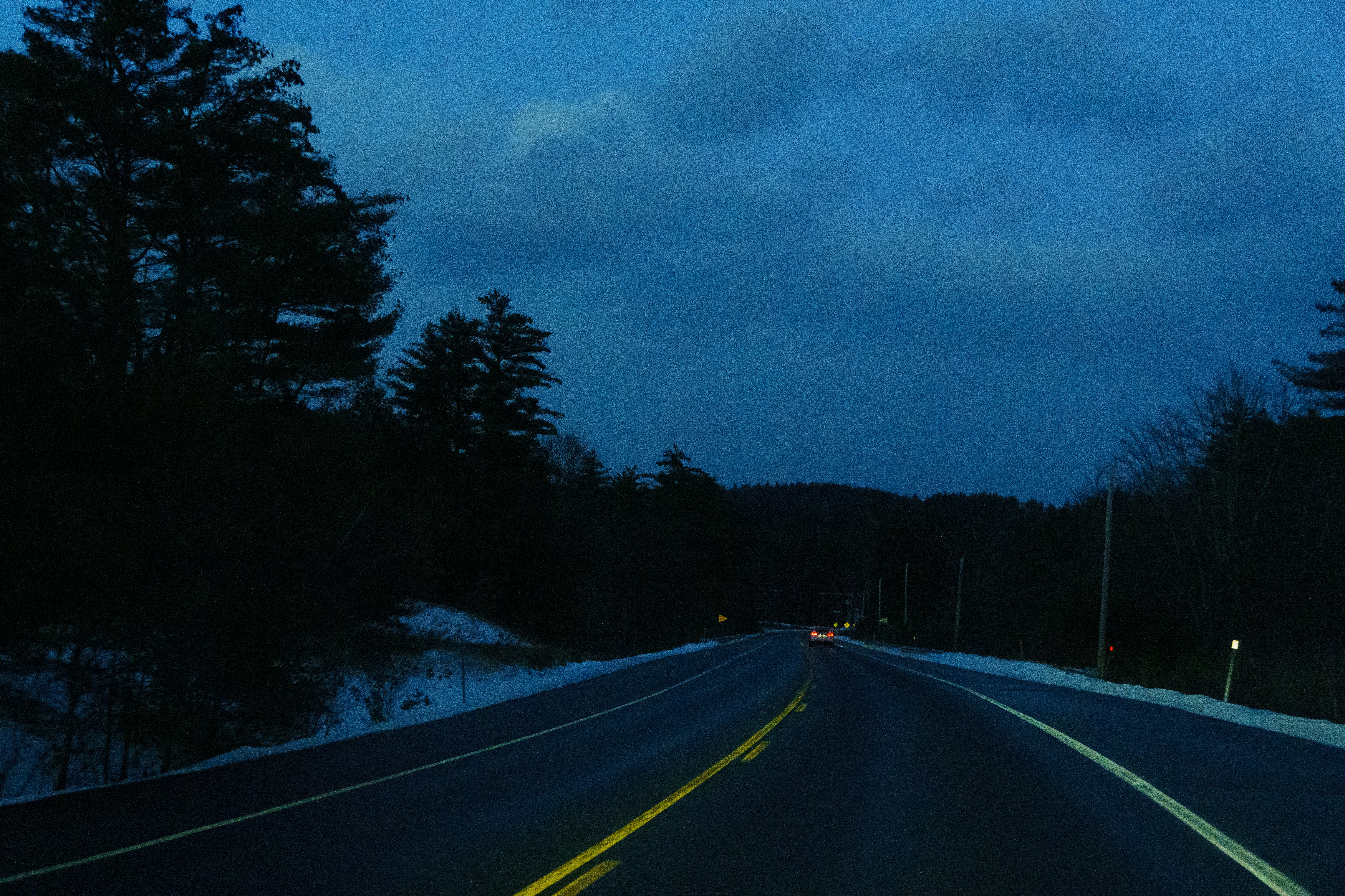 Blue Hour Descent: Snow-Swept Highway to the Distant Headlights