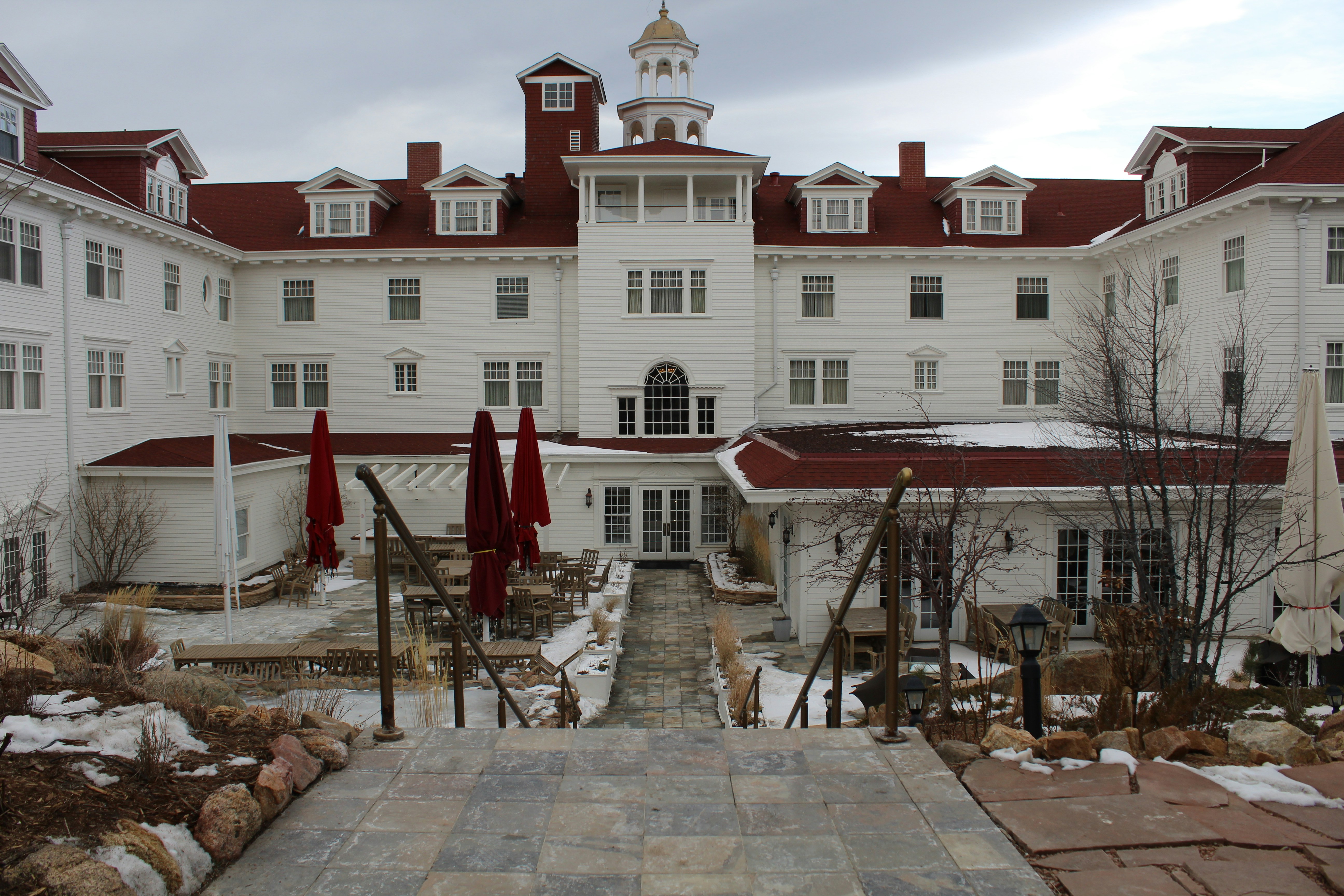 Snow-Kissed Symmetry: A White-Walled Estate Framed by Crimson Roofs