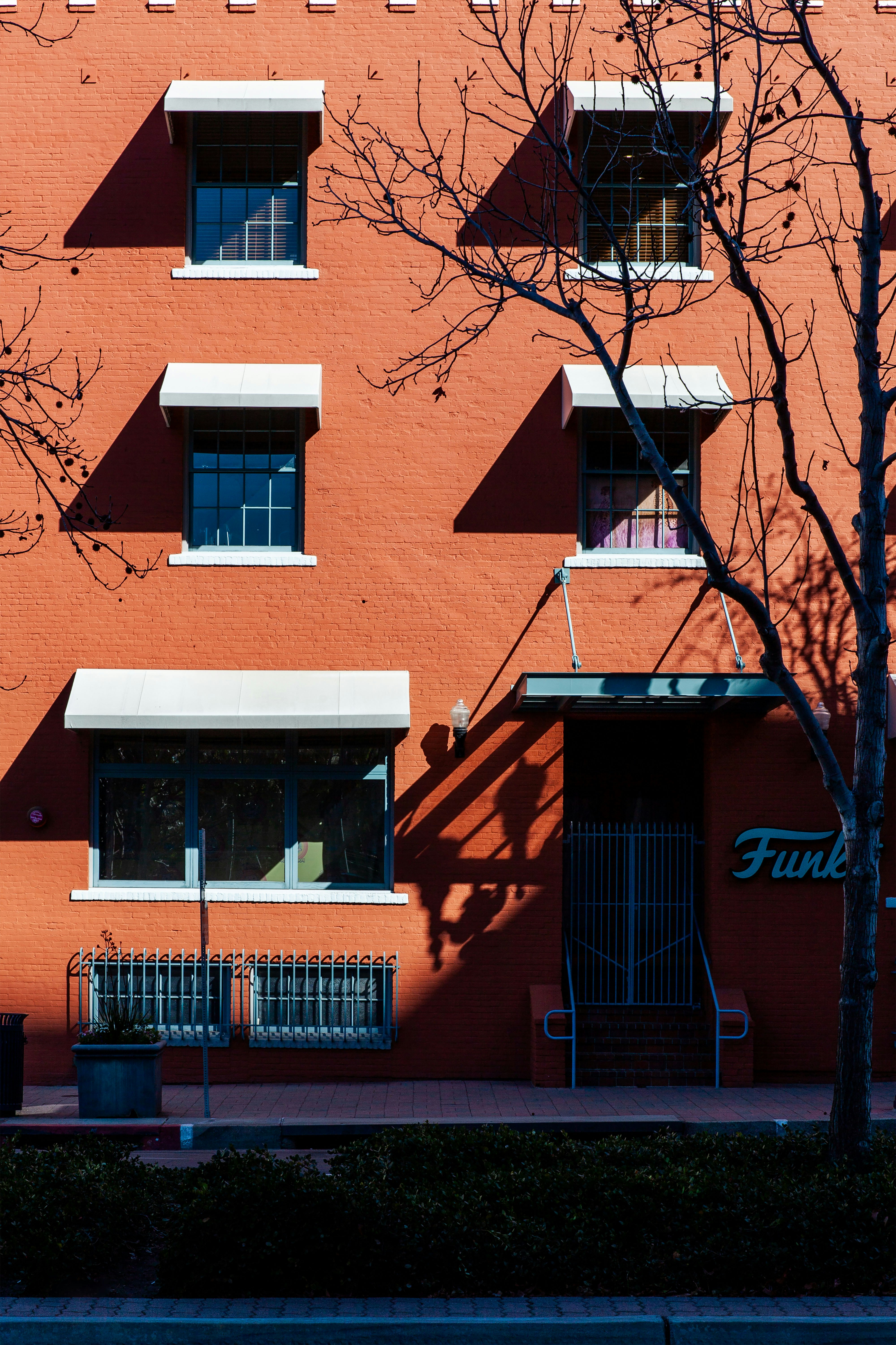 A tall red building with a clock on the front of it photo – Free San ...