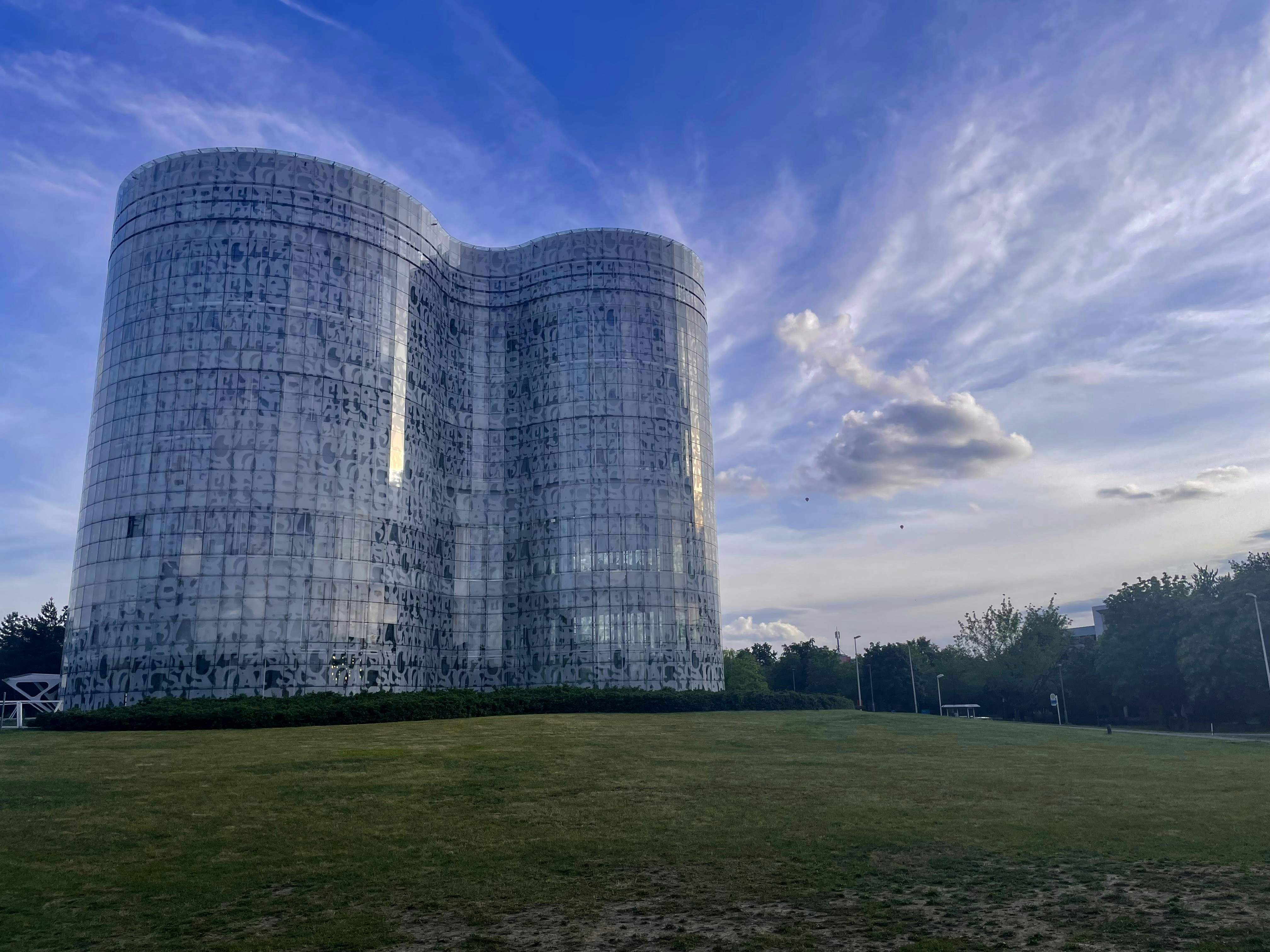 Twin Cylinders in the Grass: a Modern Facade Under a Wide Sky