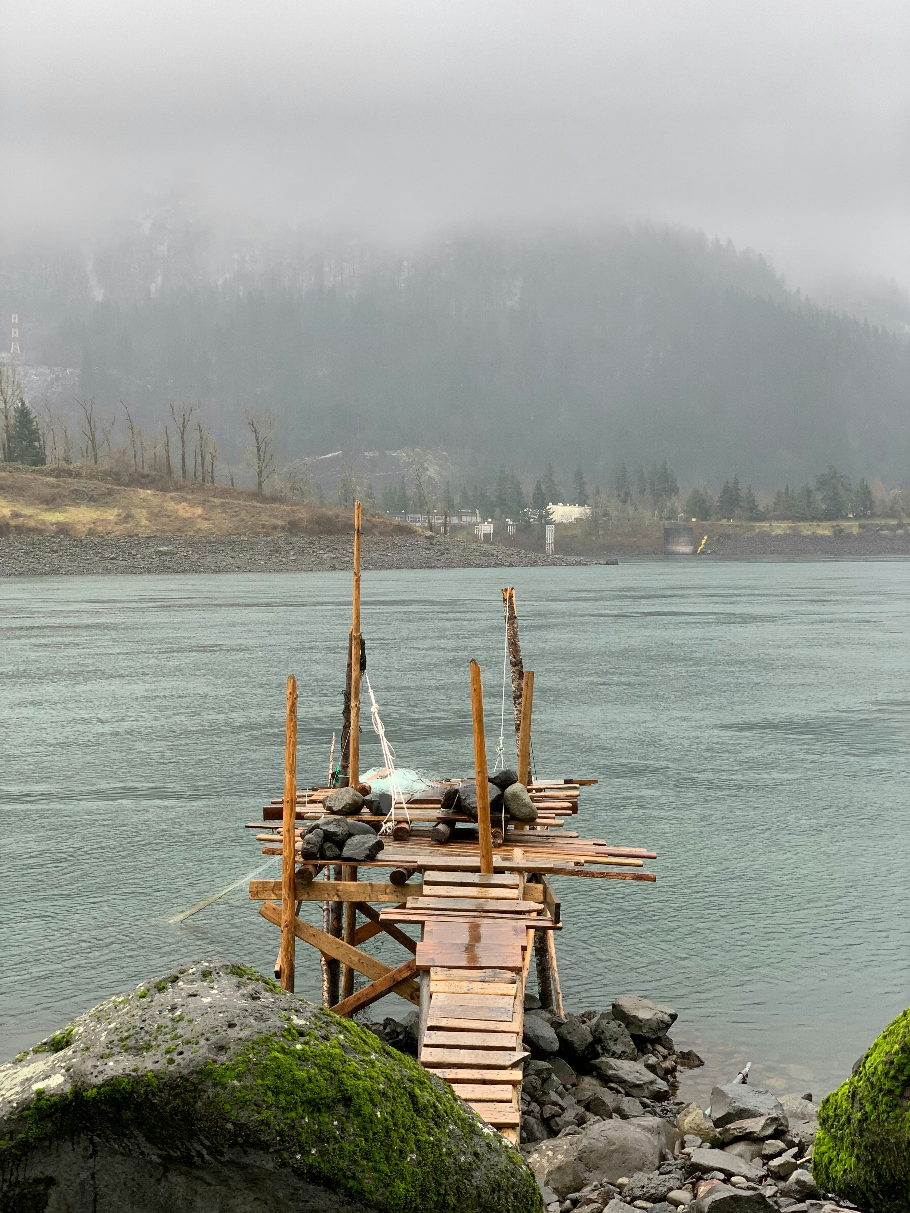Mossy Pier Reaching Through Morning Mist to a Mountain Inlet