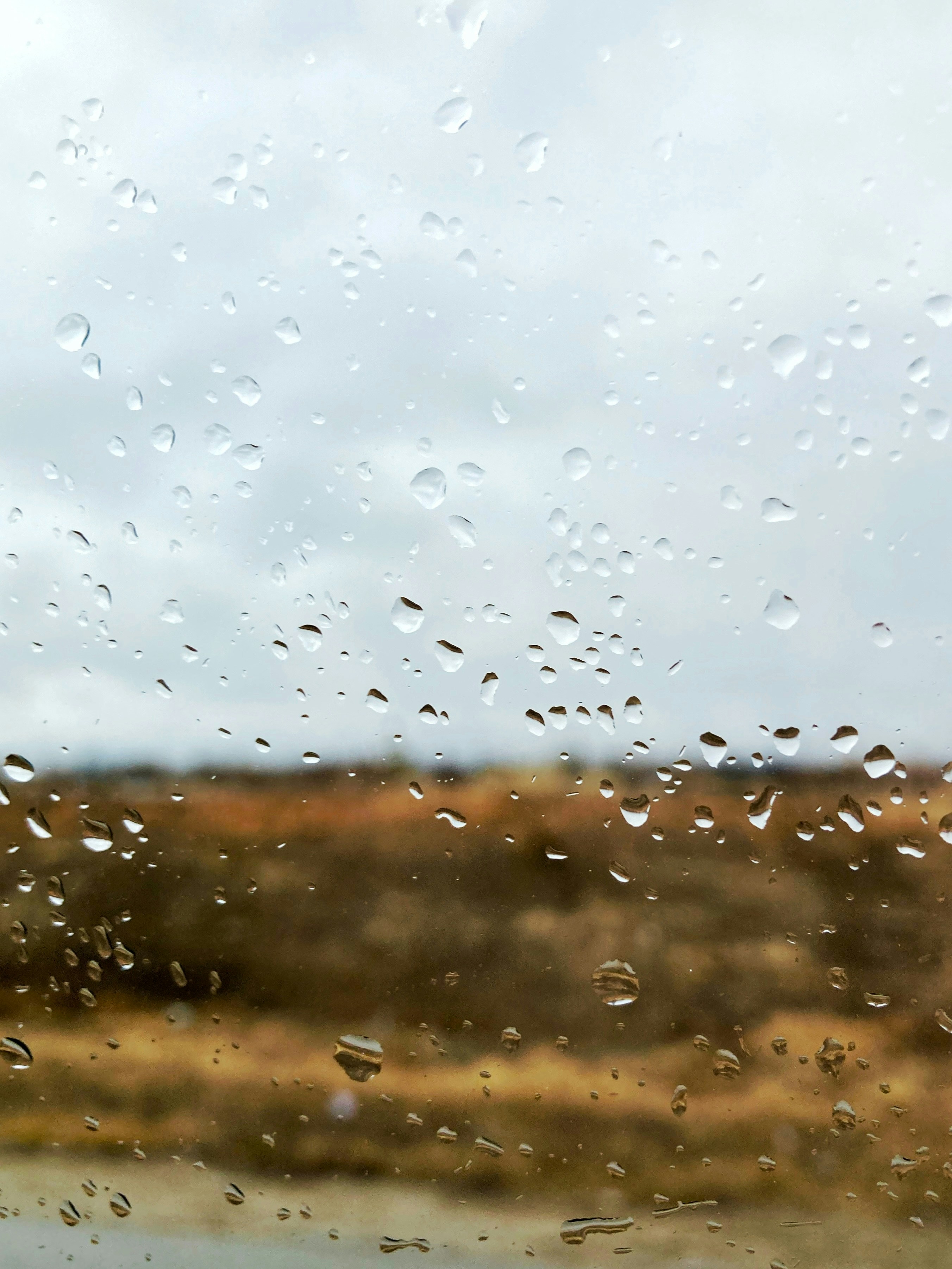 Rain-Streaked Window Framing a Distant Horizon