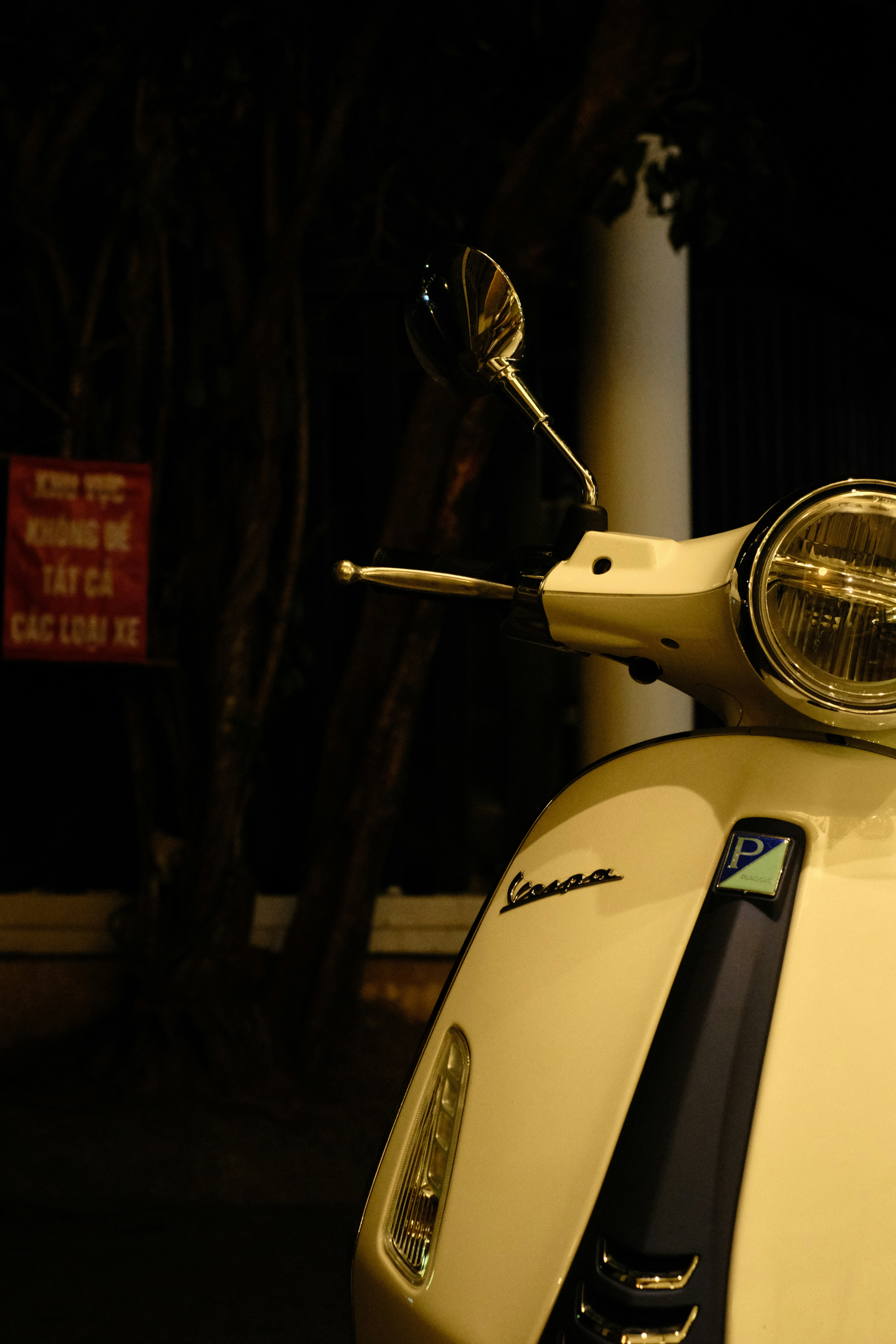 Amber Streetlight on a Cream Vespa: Nighttime Close-Up