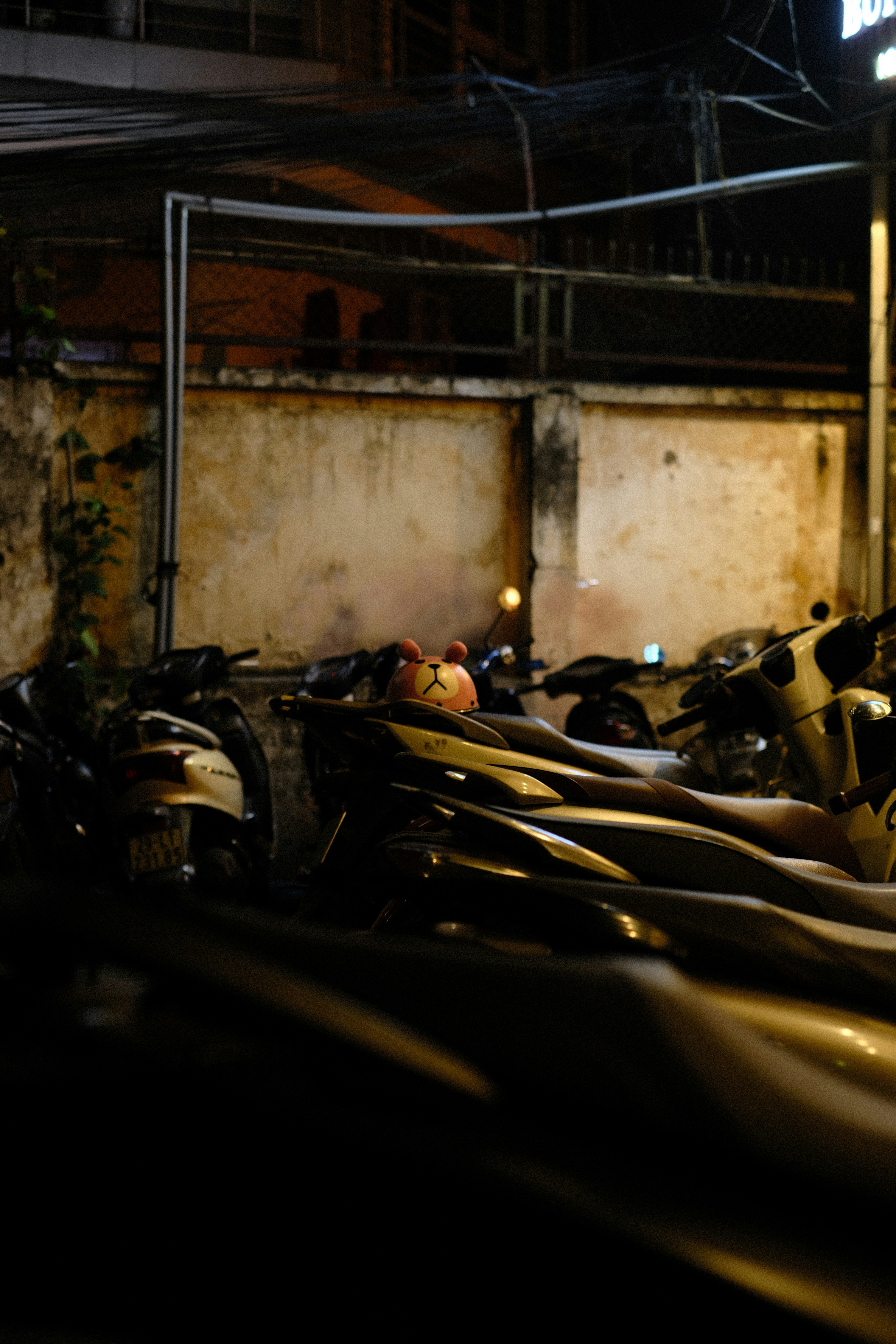 Midnight Alley: Row of Scooters Resting Under Dim Urban Lights