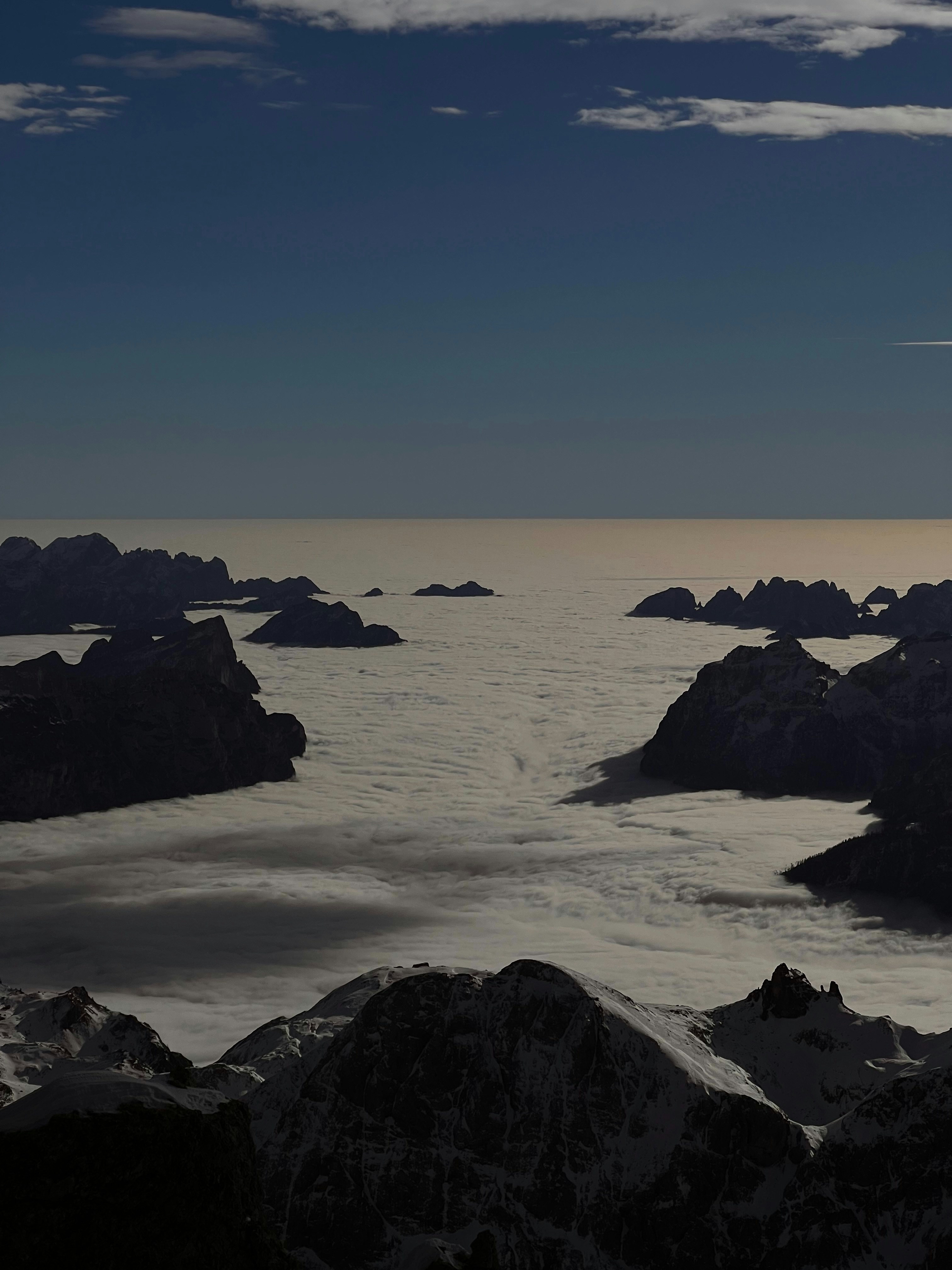 Ridgeline Horizon: Snow-Kissed Peaks Beneath a Quiet Sea