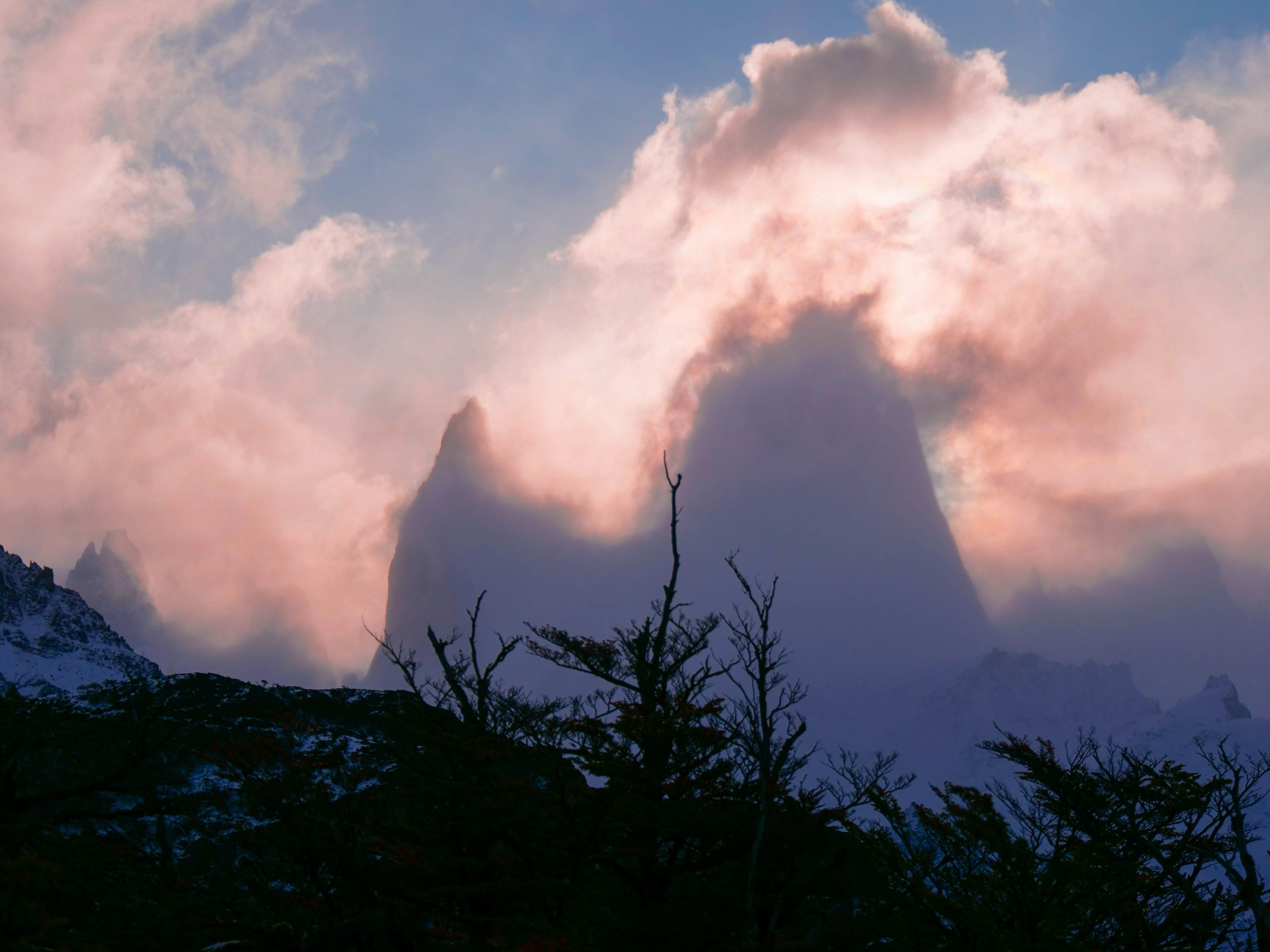 Sunset Veil over the Spire: Pink Clouds Crown a Snowy Peak
