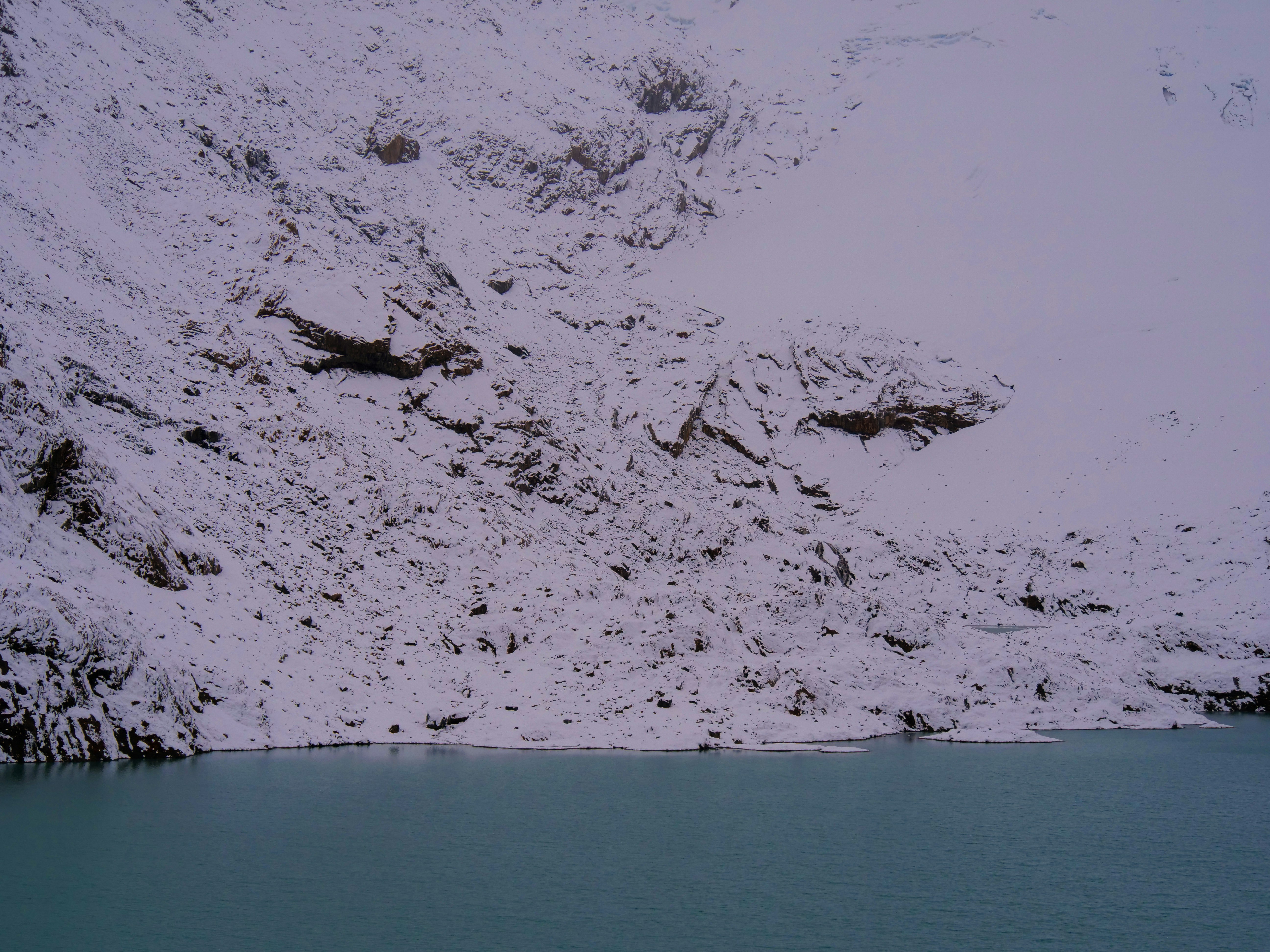 Edge of a Snow-Clad Cliff Over Turquoise Fjord