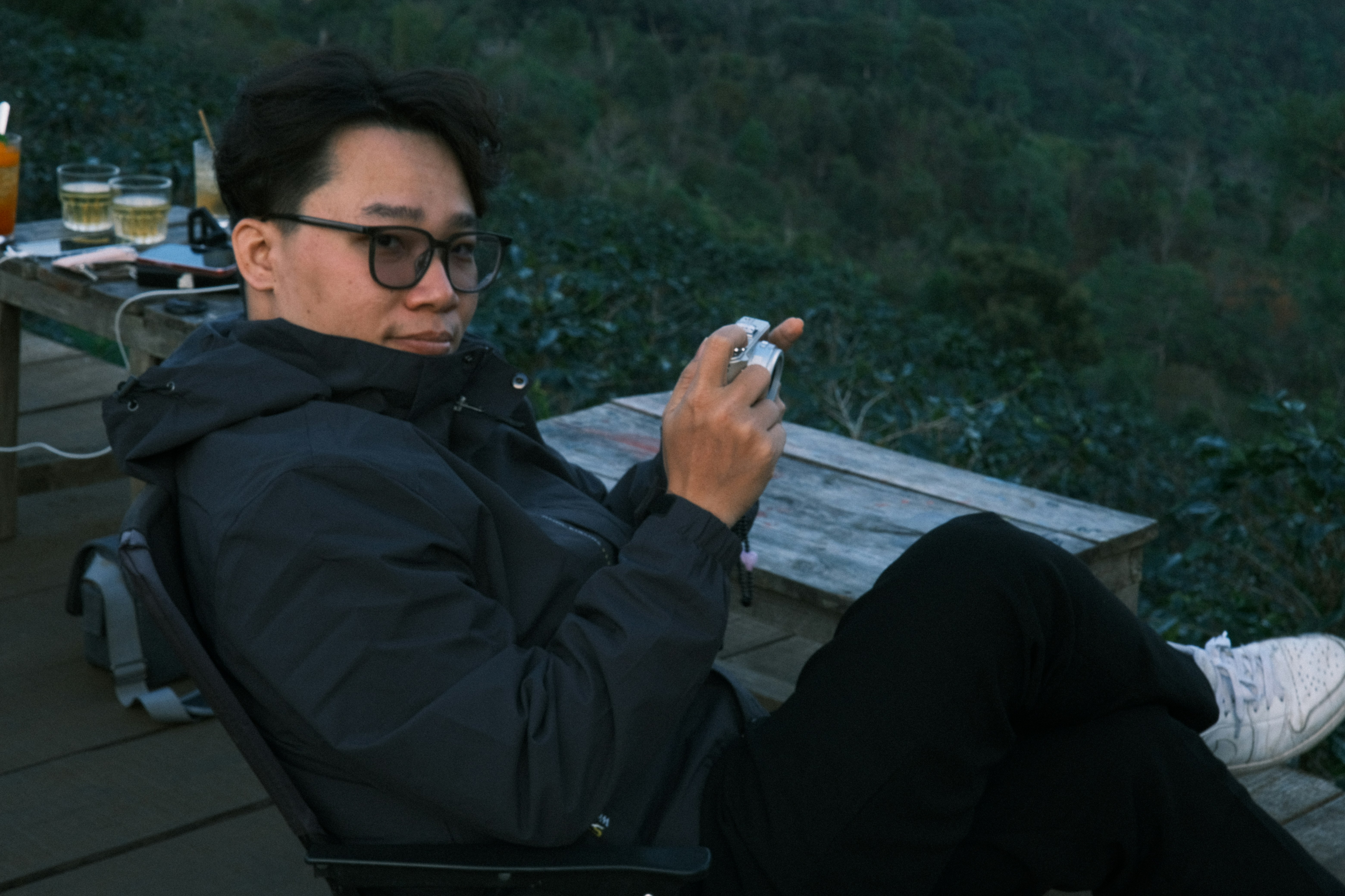 A man sitting in a chair holding a cell phone photo – Free Man Image on ...