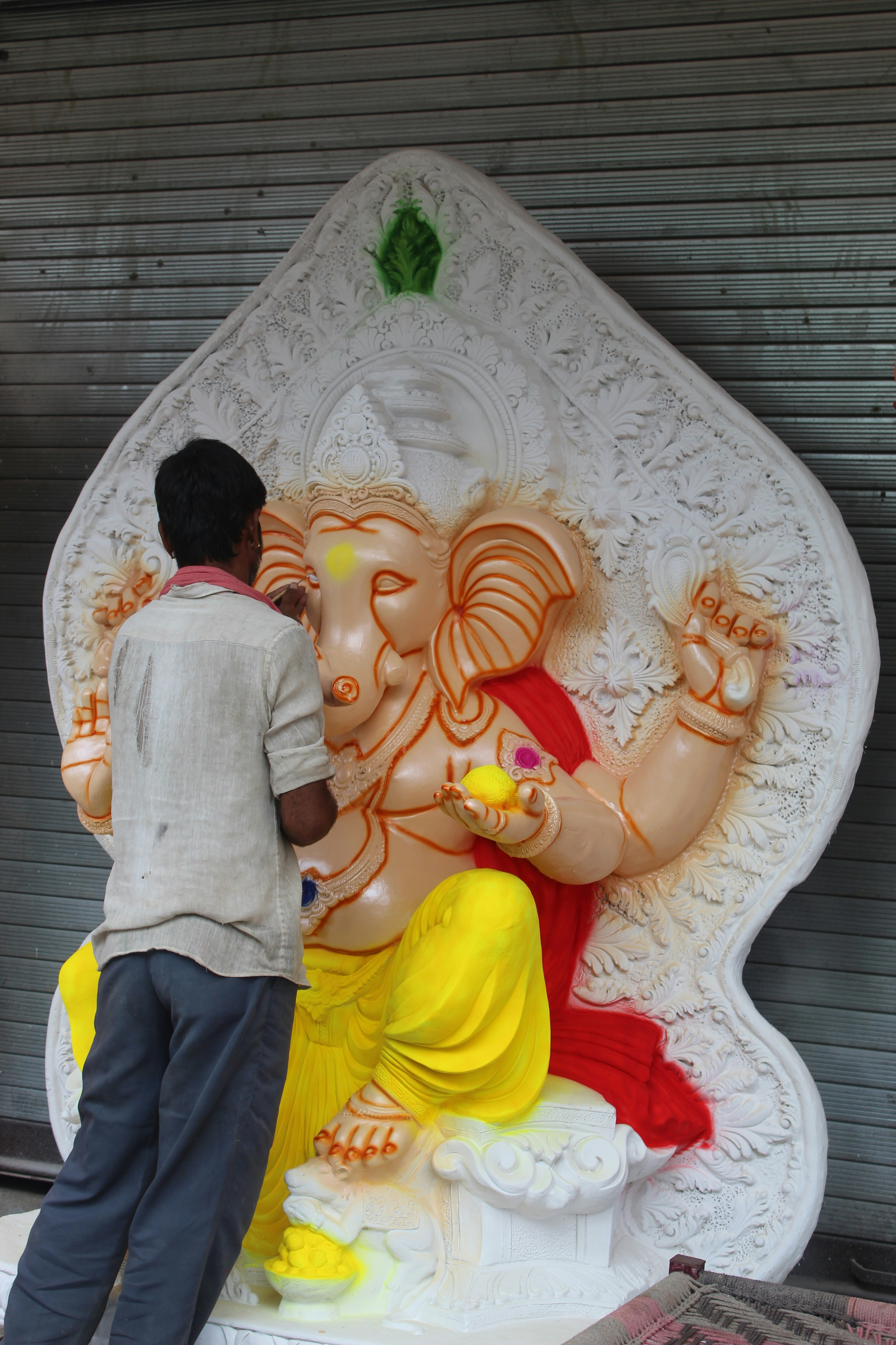 Coloring Blessings: A Craftsman Brushing Life onto a Ganesha Idol