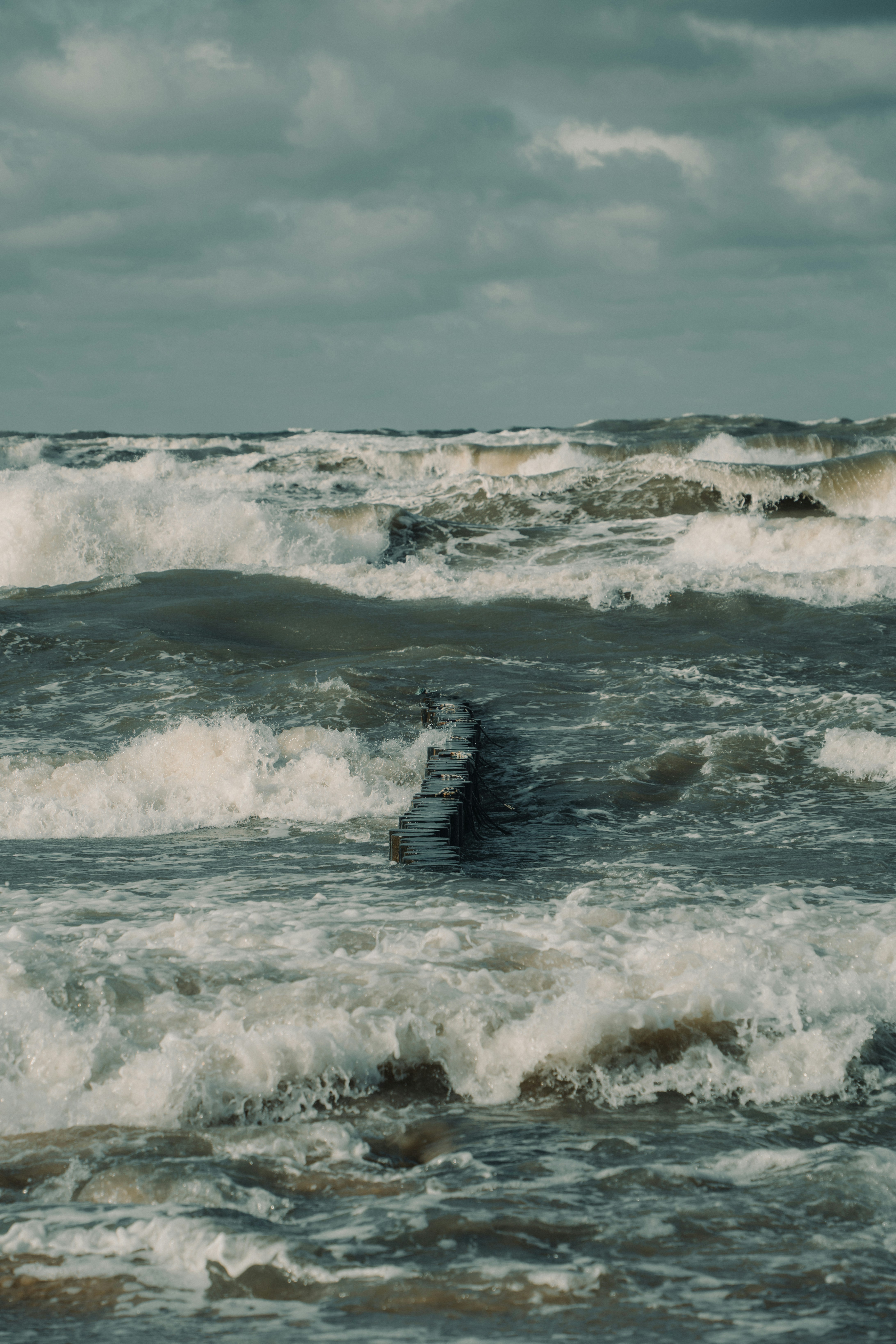 Jetty in the Whitecaps: A Weathered Breakwater Faces the Open Sea