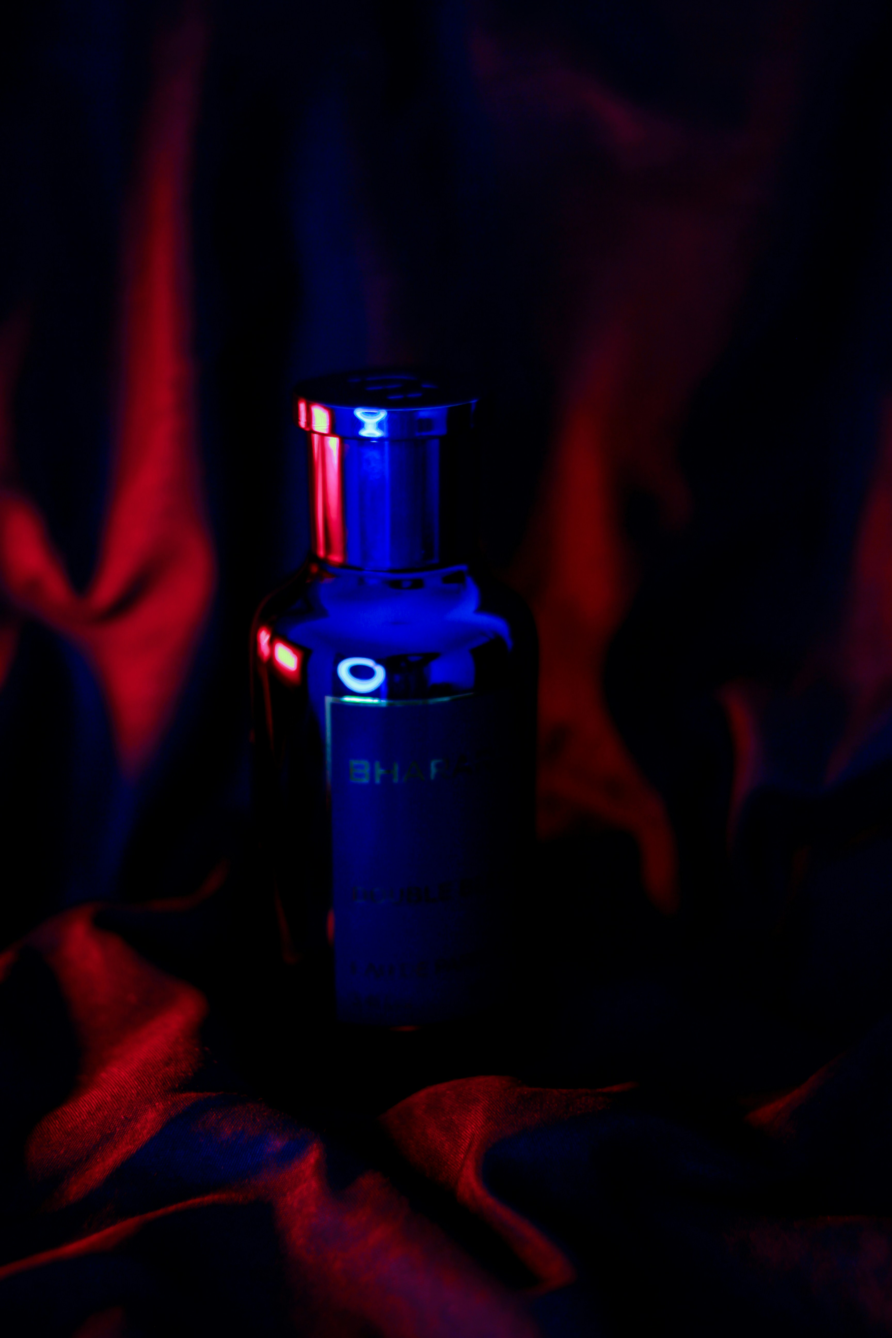 Neon Reverie: A Perfume Bottle Drenched in Velvet Red and Electric Blue