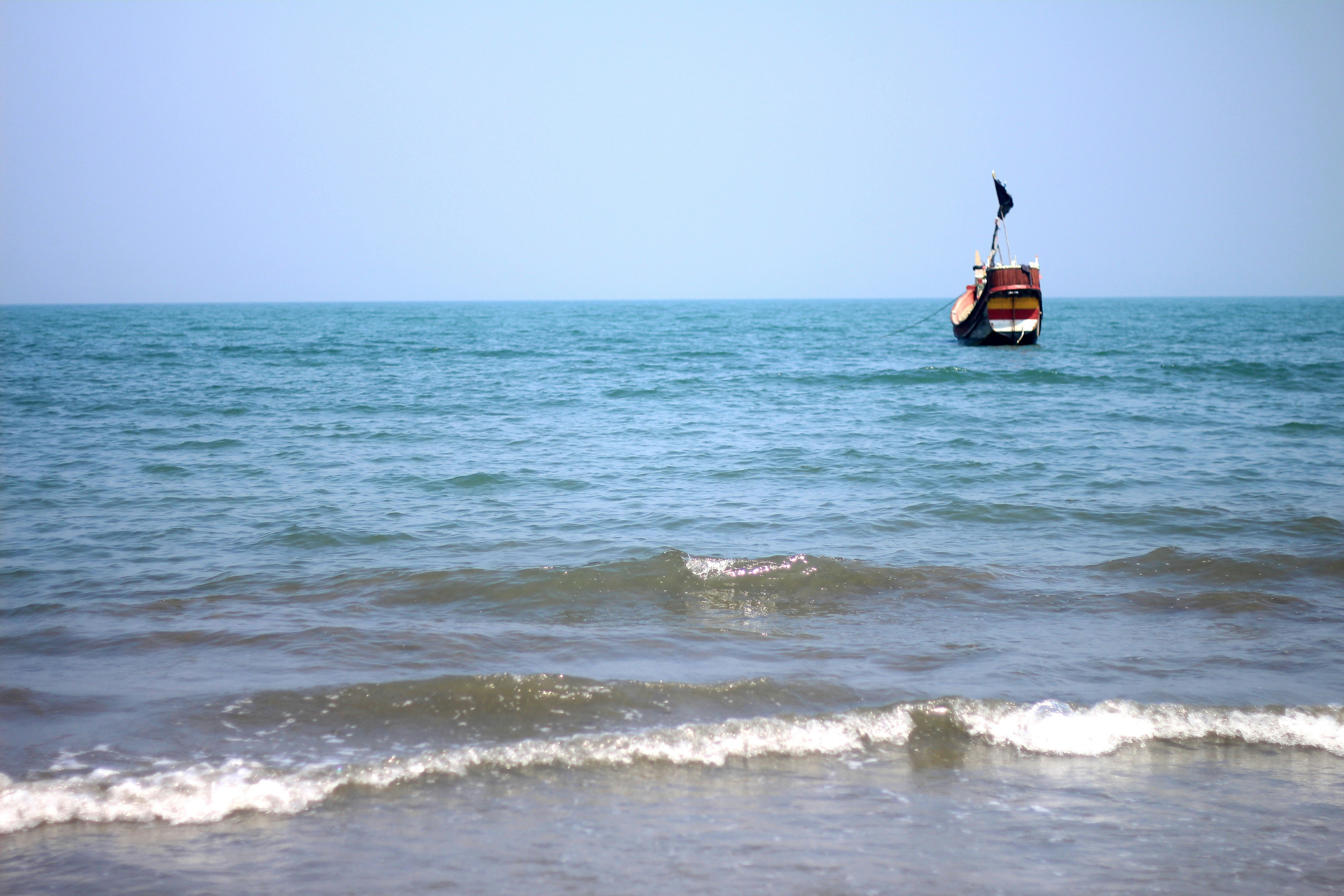 Lone Vessel at the Glimmering Horizon Over a Glassy Sea