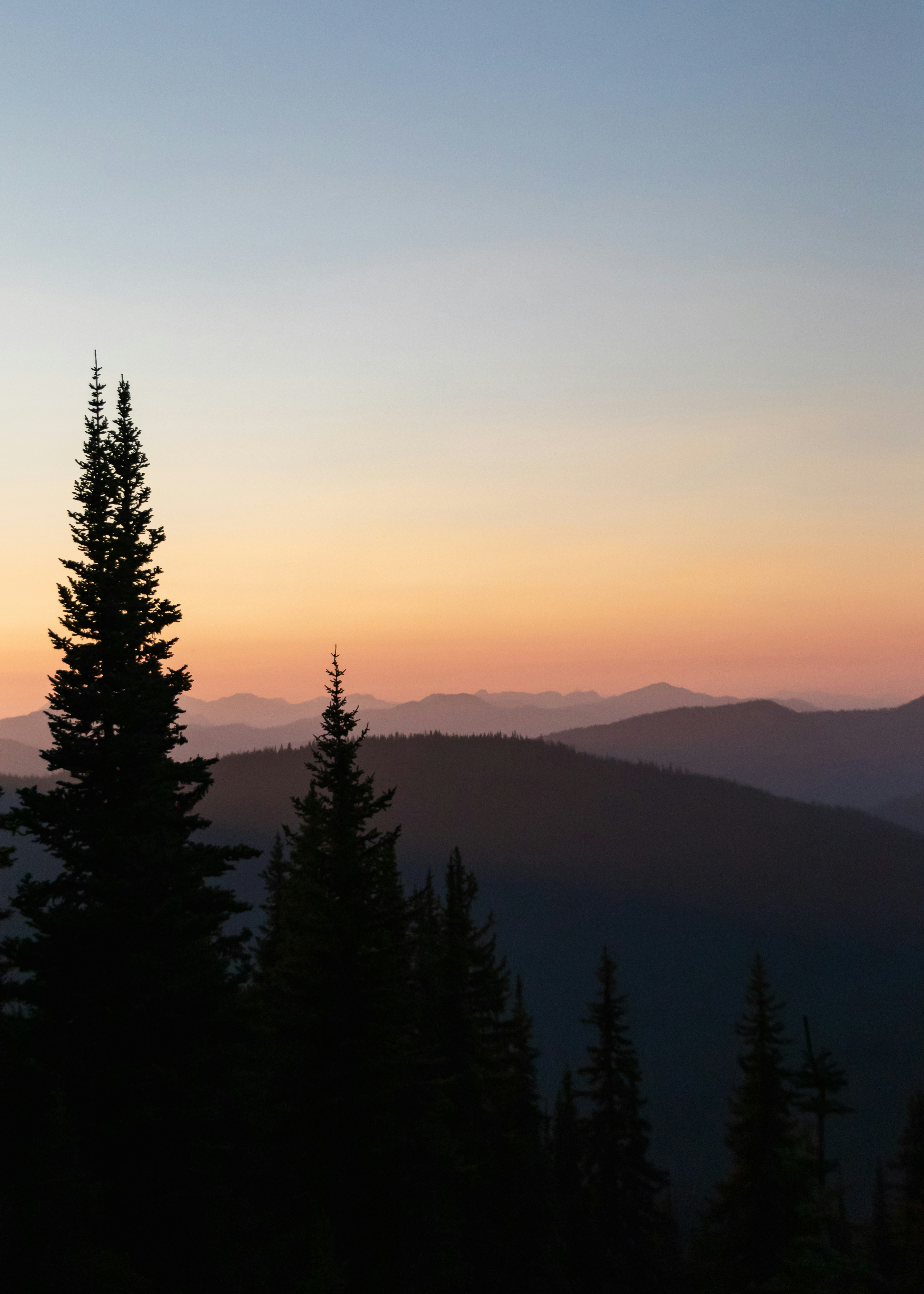 The sun is setting over the mountains and trees photo – Free Outdoors ...