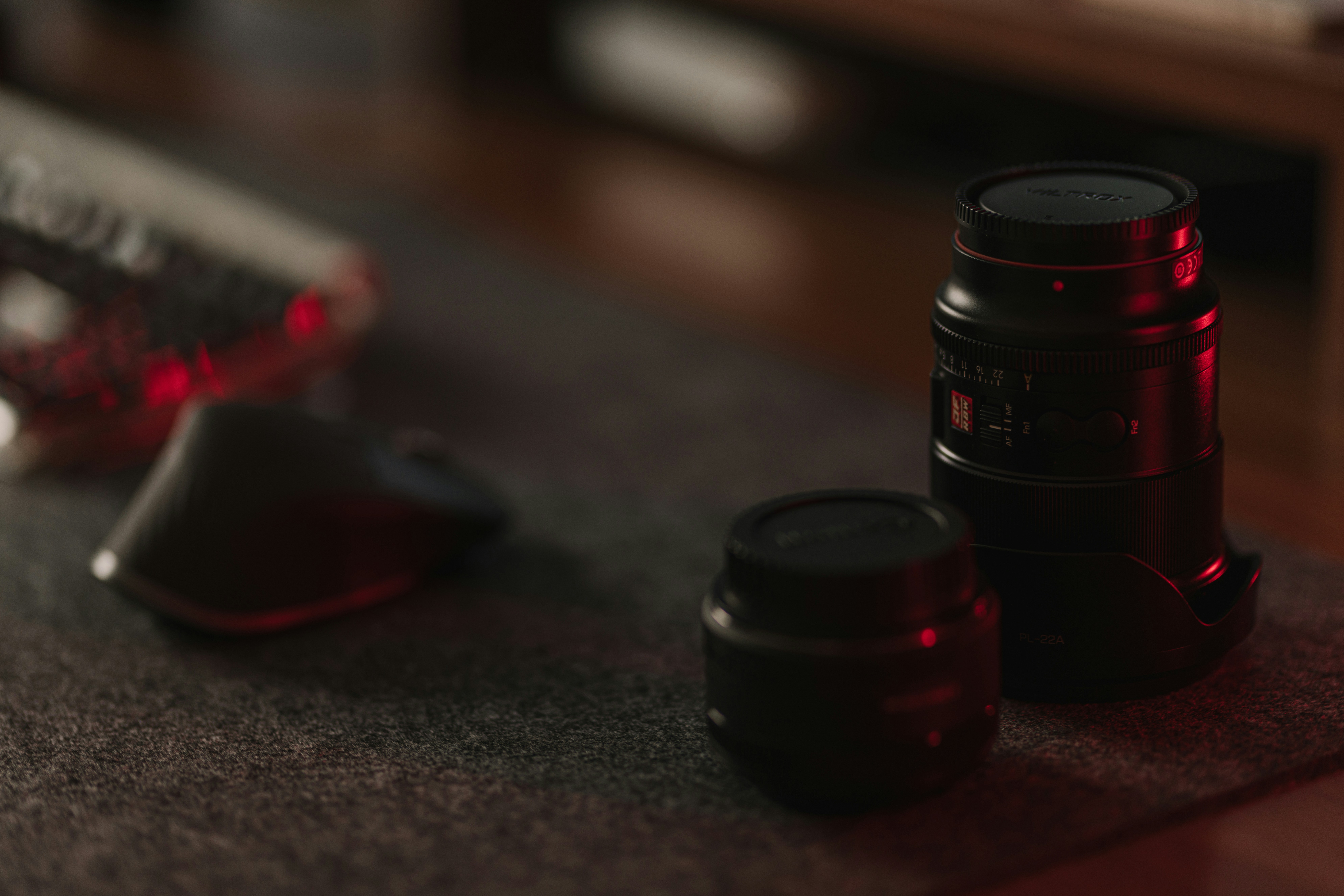 Crimson Focus: Lenses Resting in a Quiet Studio Glow