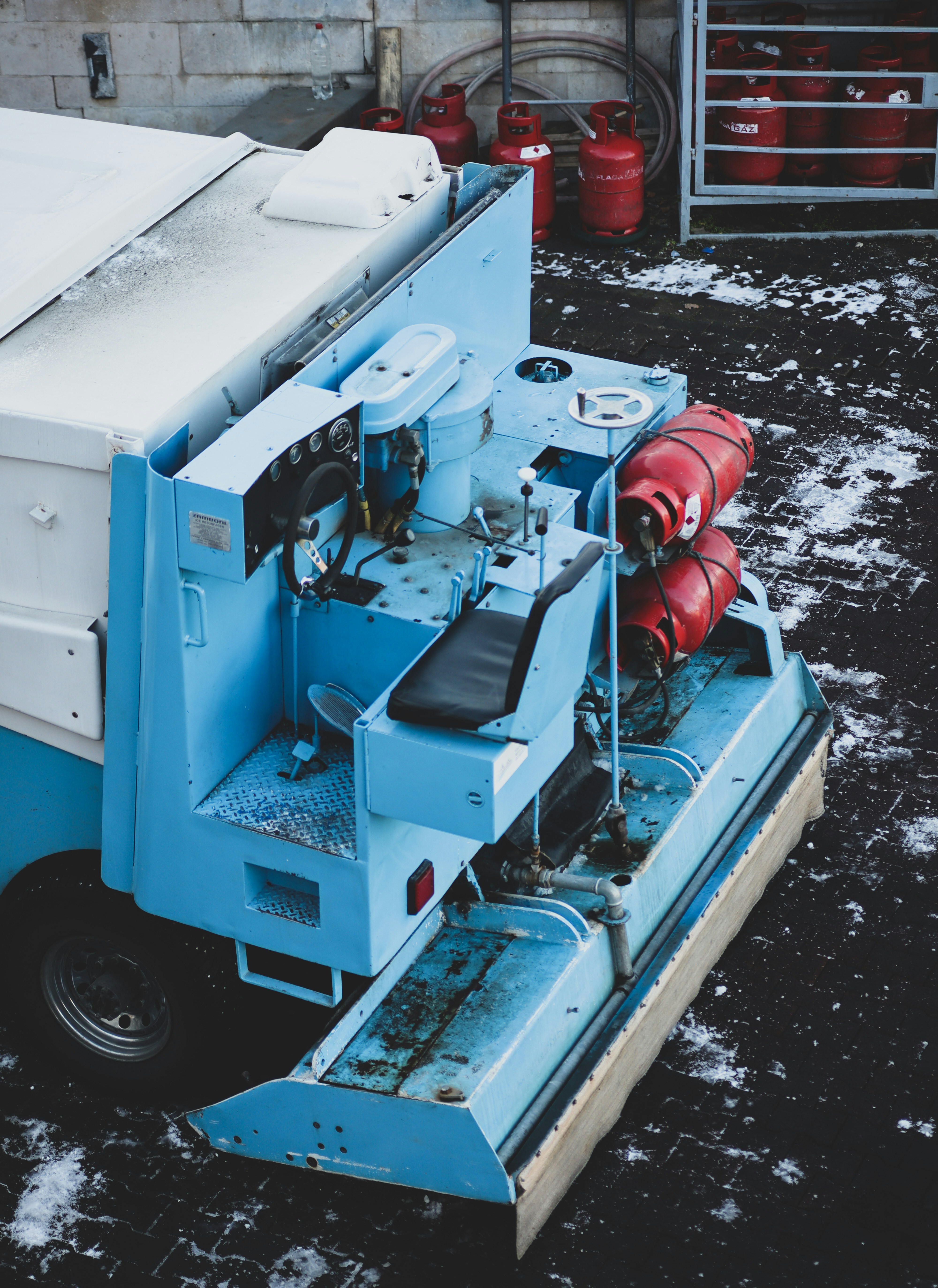 Ice-Blue Workhorse: Snow-Dusted Maintenance Rig with Red Cylinders