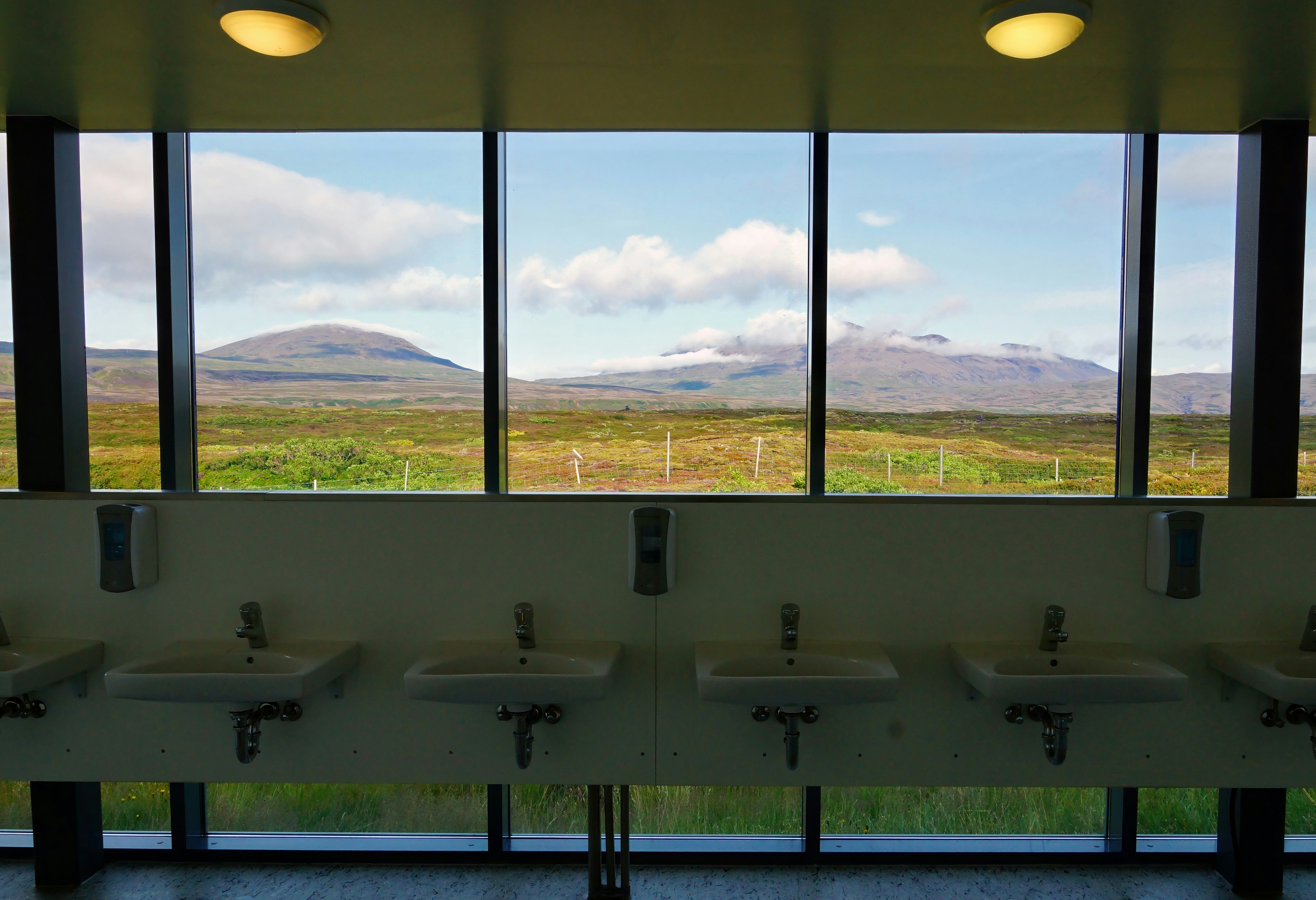 Horizon Through the Sinks: Mountain Vista Framed by a Public Bath Window