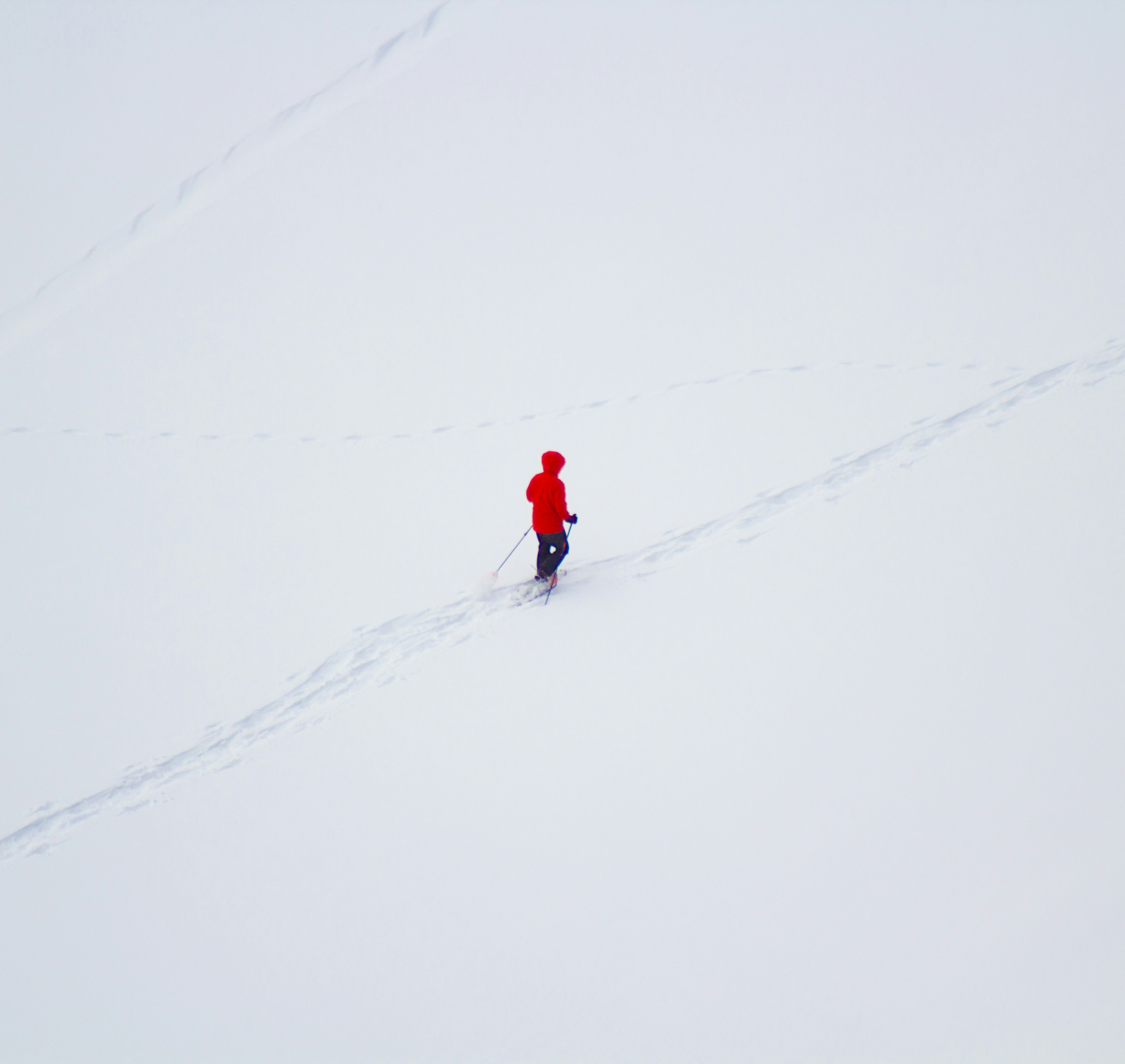 Scarlet Climber Tracing Quiet Lines Across a Powdered Summit