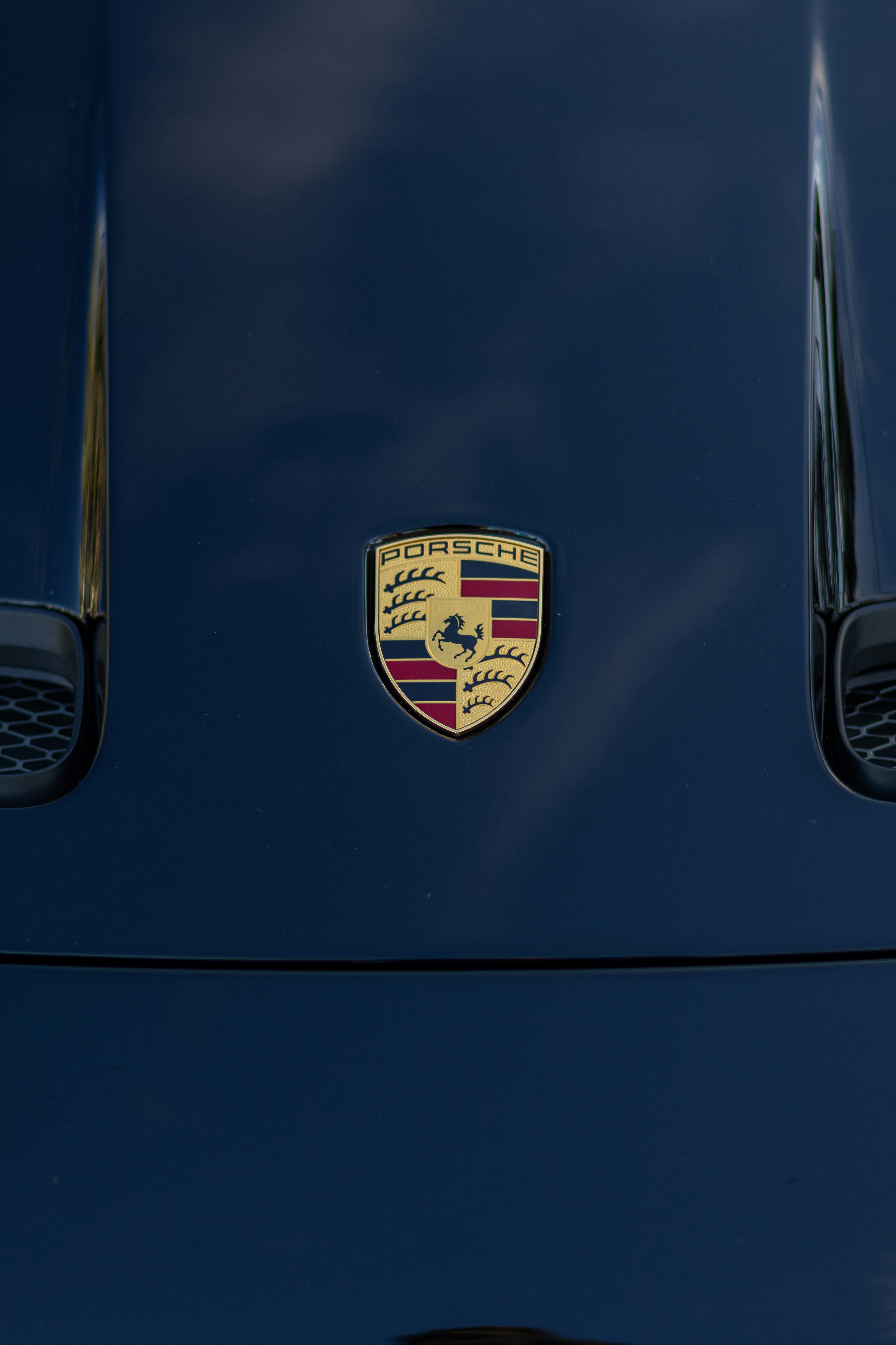 Crested Precision: Porsche Badge Anchors a Midnight-Blue Hood