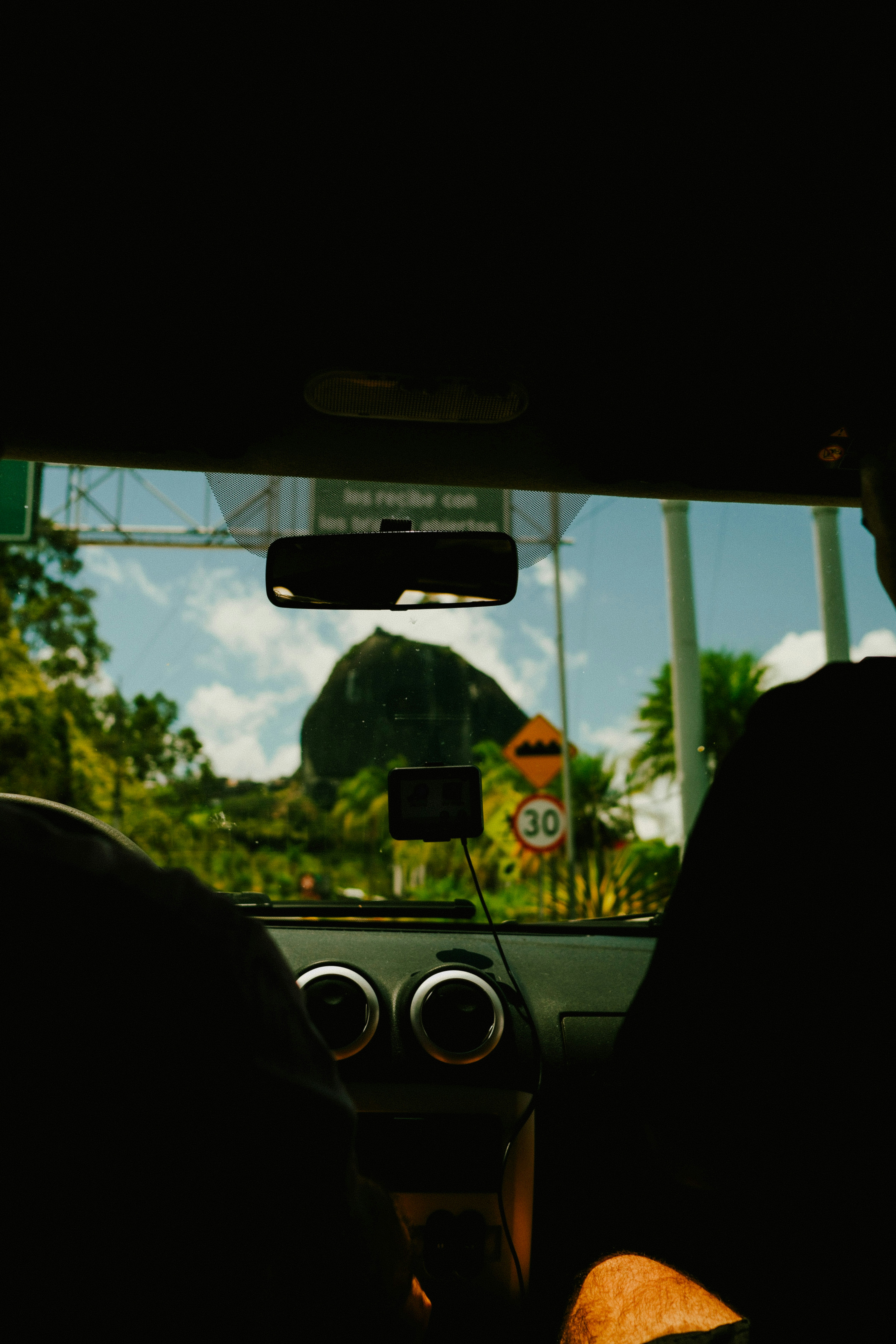 Windshield Vista: Road Signs Framed by a Quiet Car Interior