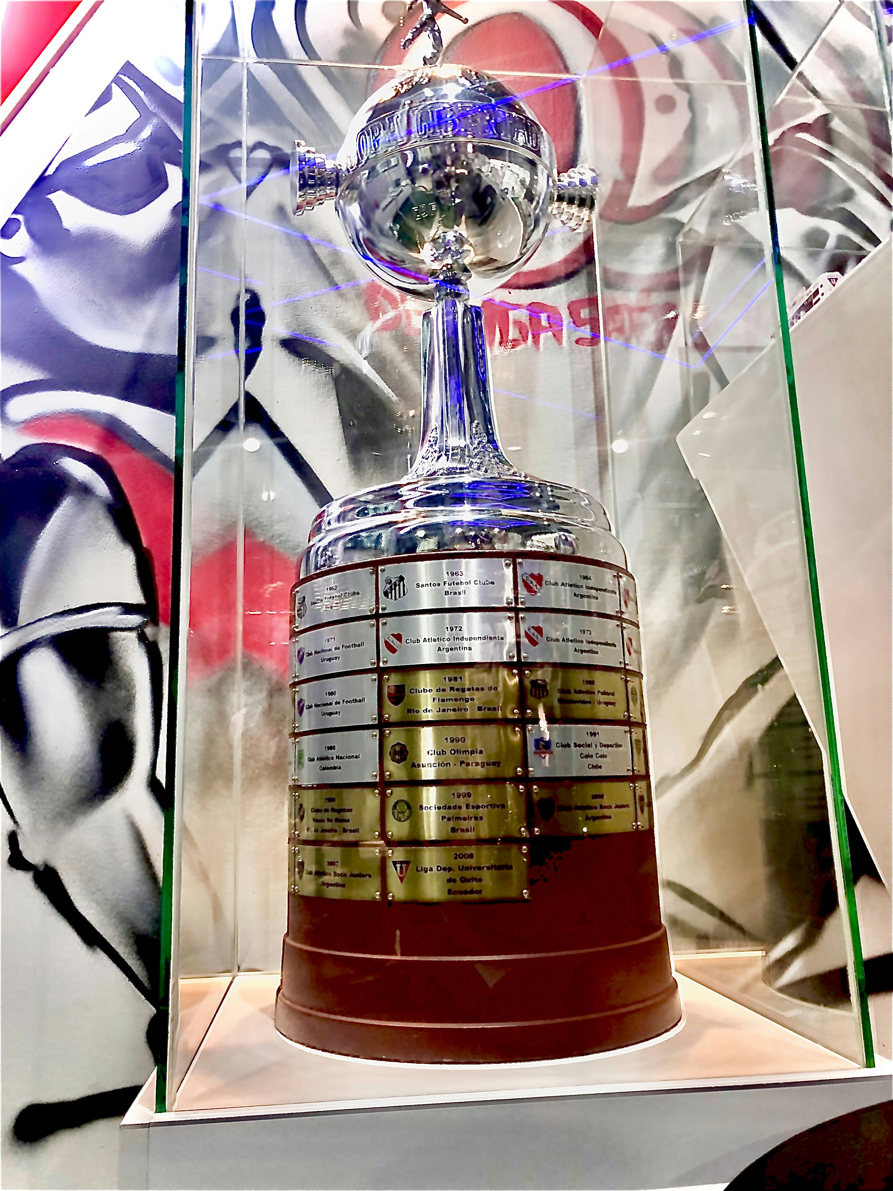 Chromed Summit: A Trophy Encased in Glass Amid Neon Graffiti