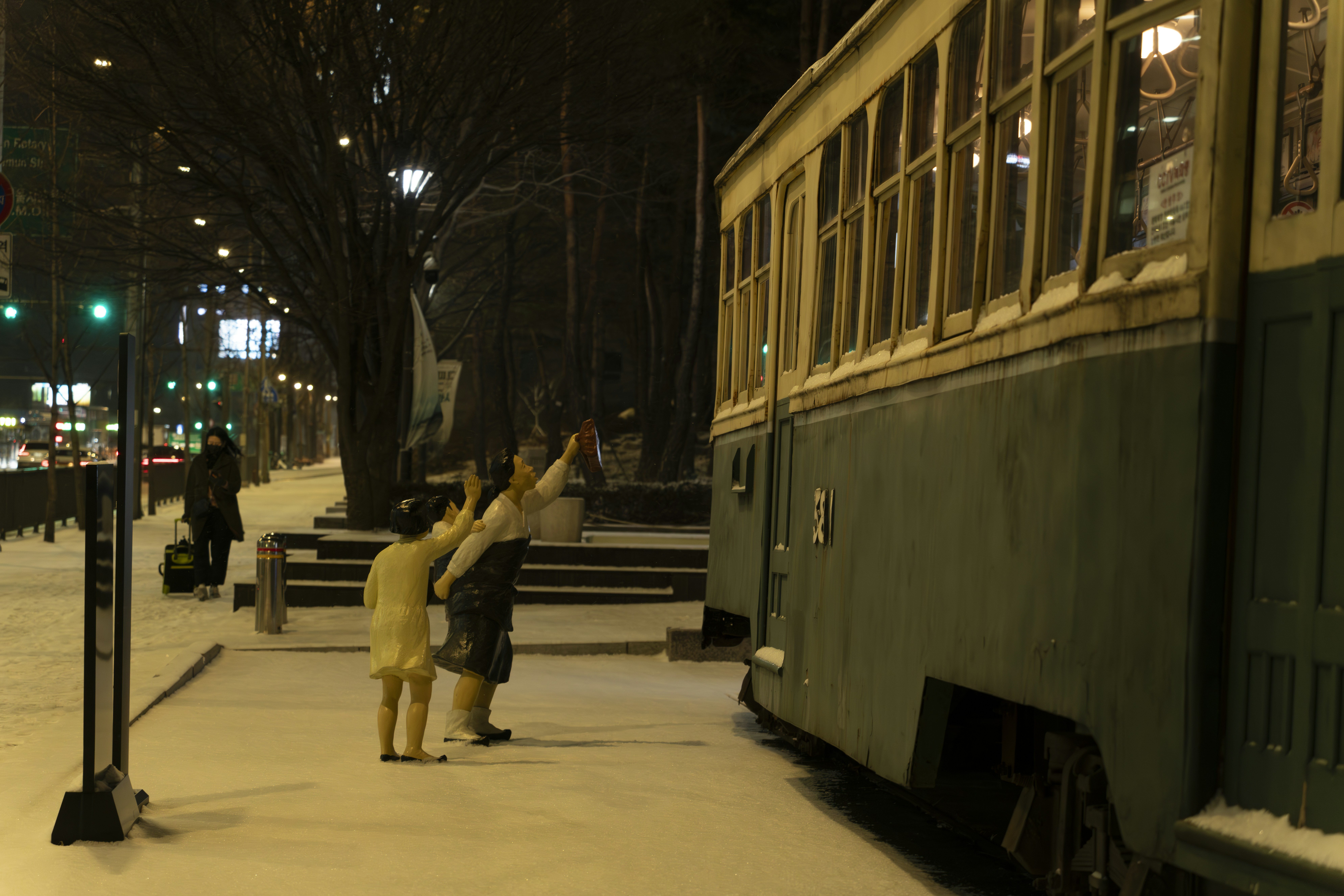 Snowy Streetside Gesture: A Moment by the Old Tram