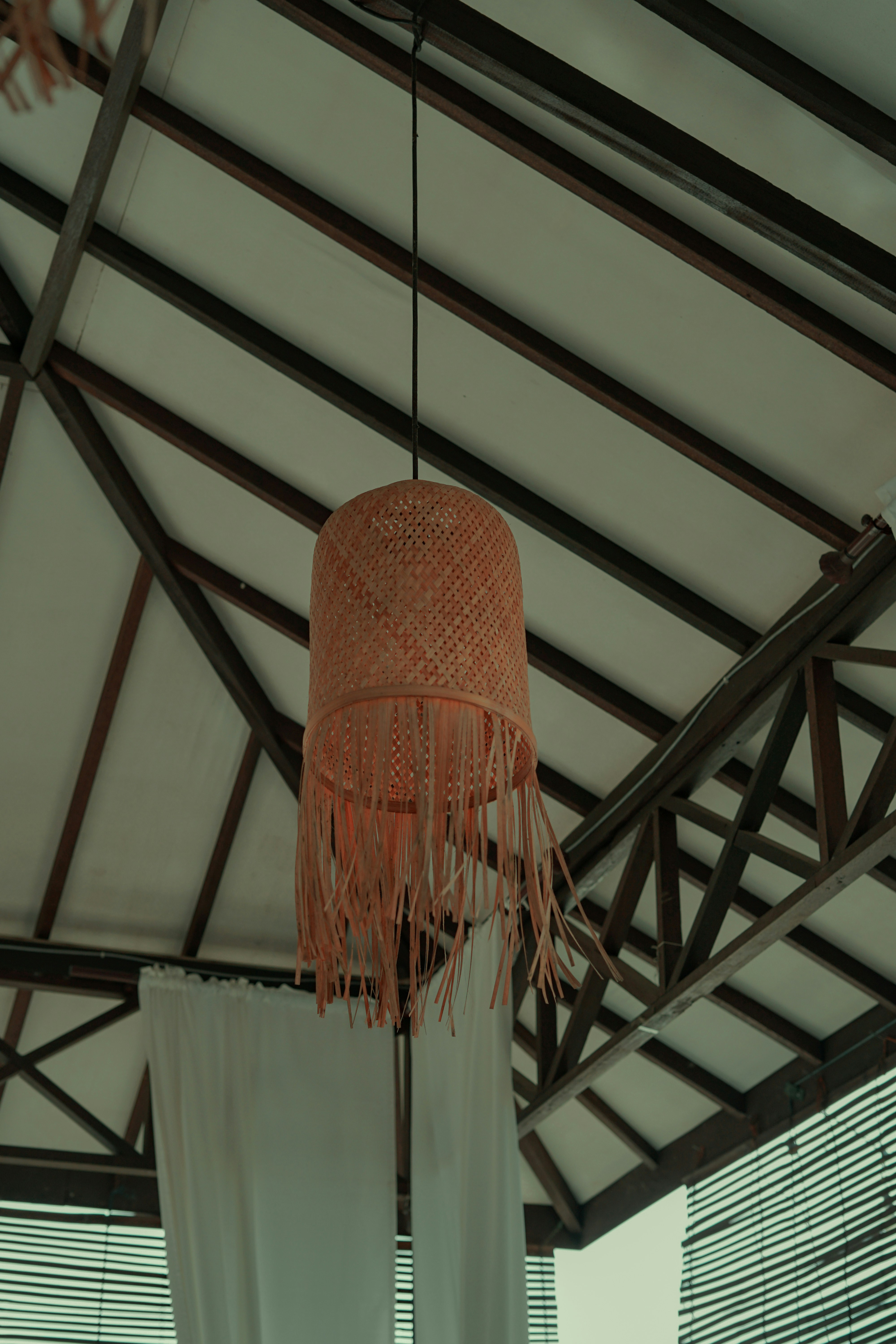 Hanging Woven Lantern Under Geometric Timber Roof