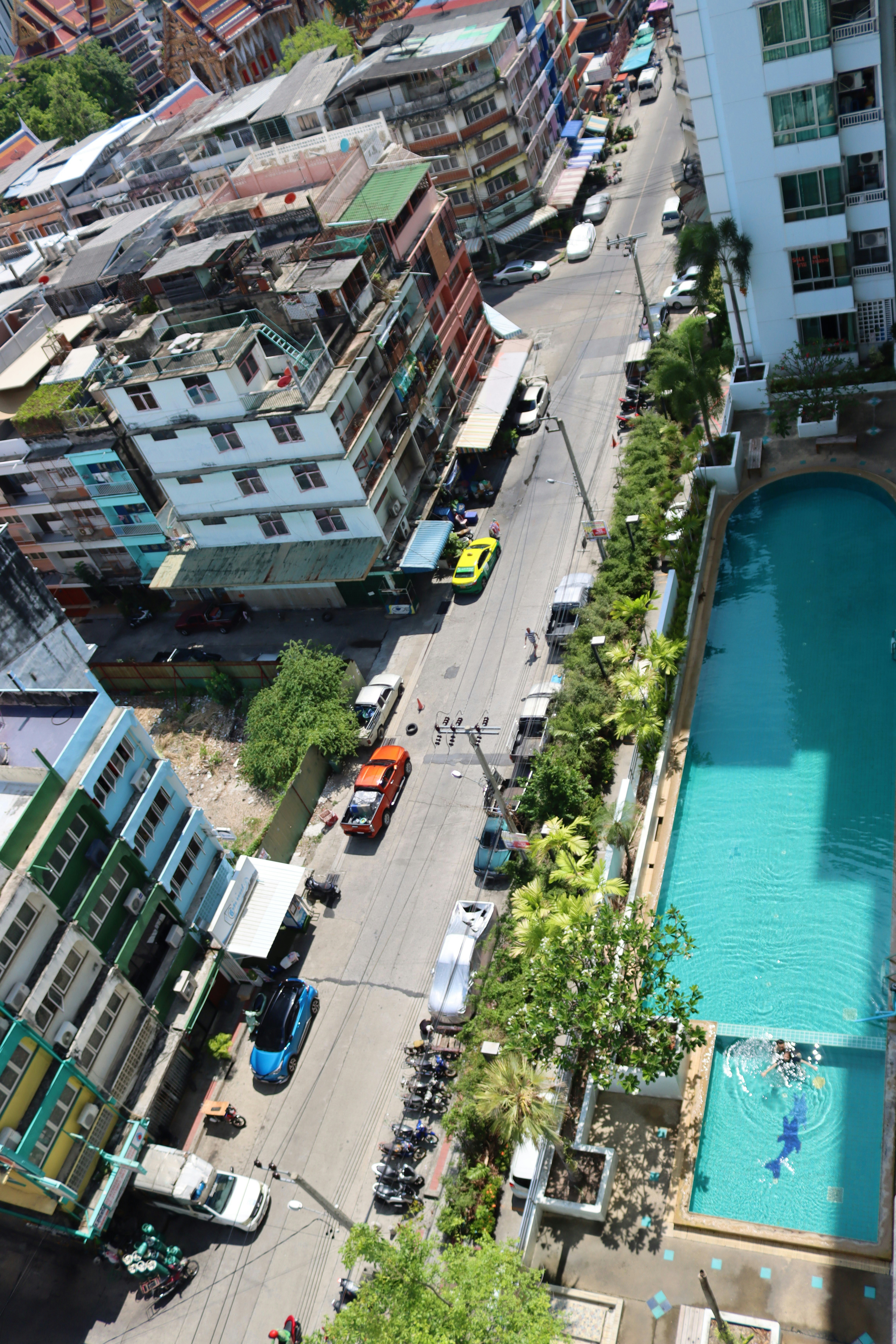 Tilted Street Odyssey: Yellow Taxi Winding Past a Turquoise Oasis