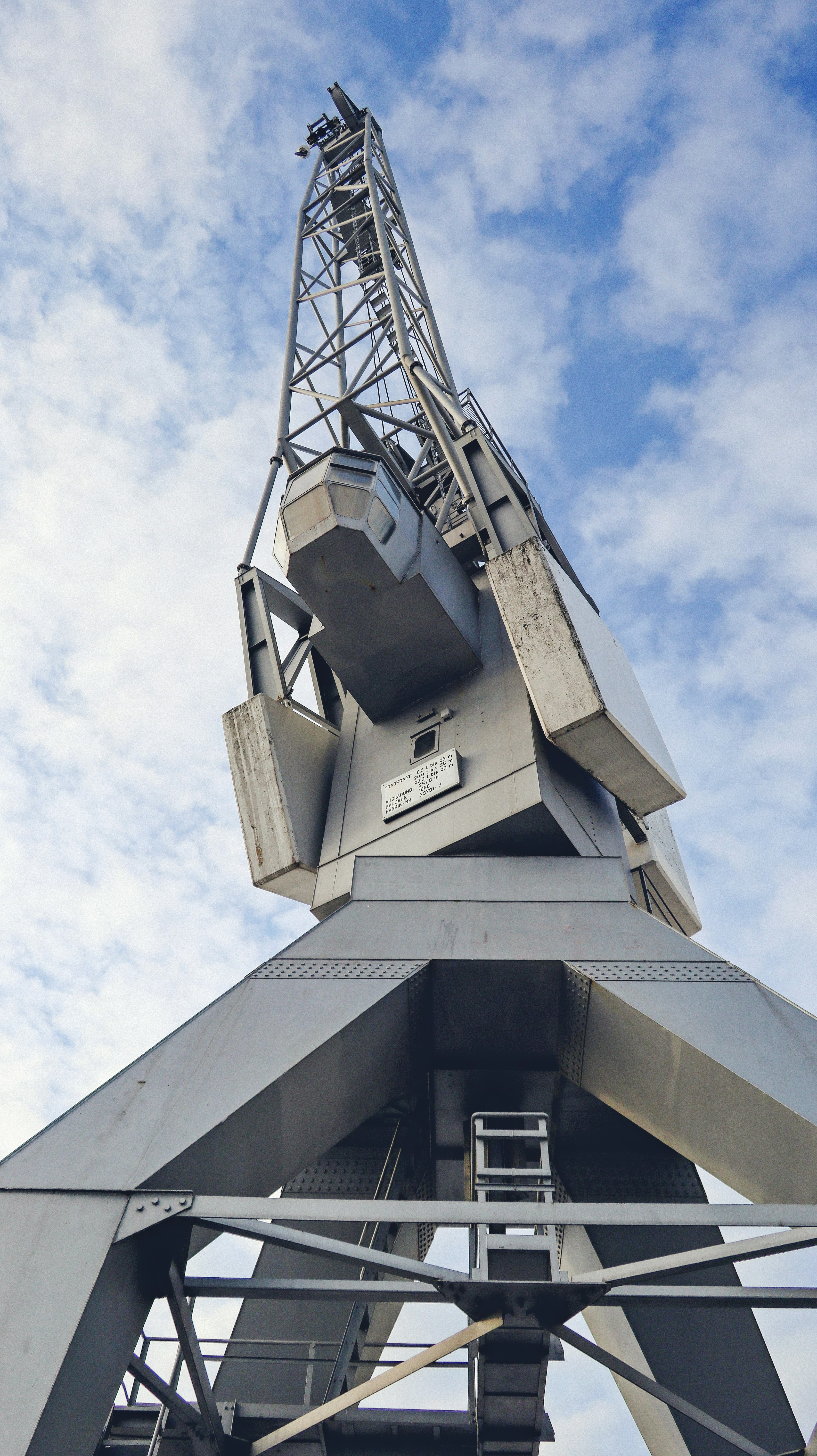Ascendant Lattice: Ground-Level Portrait of a Towering Crane Against the Sky