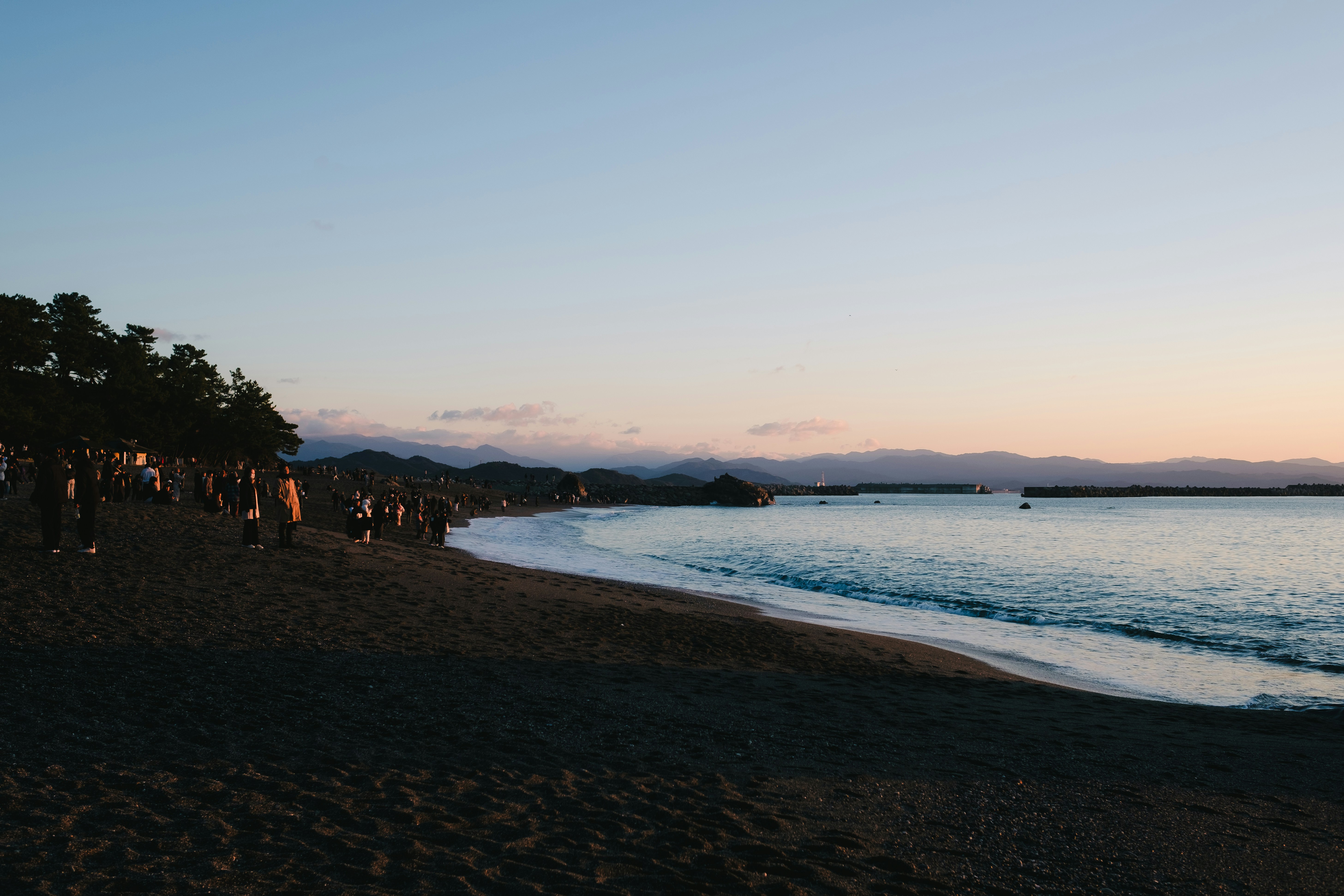 Shoreline Dusk: A Quiet Horizon Framed by a Crowded Beach