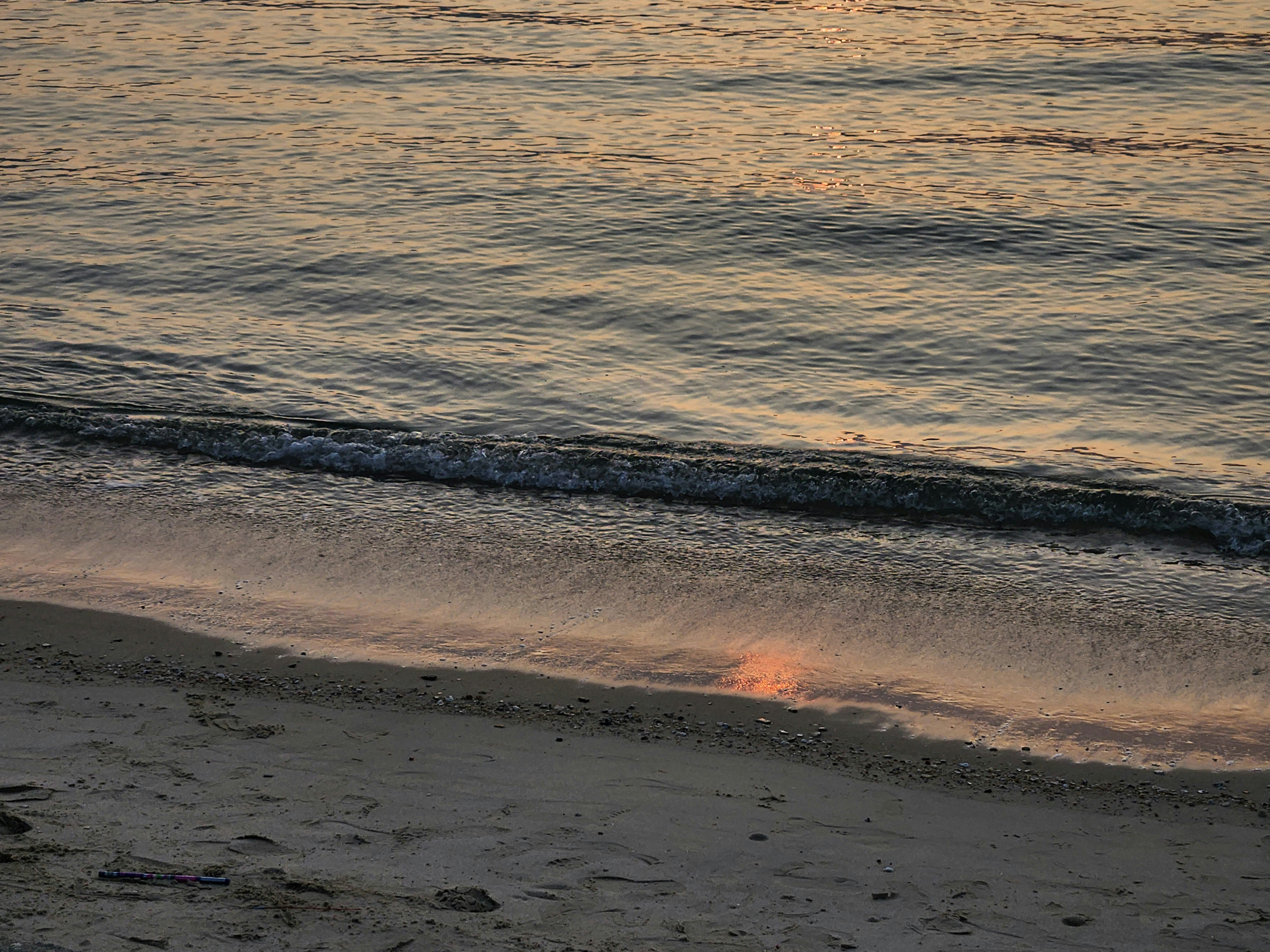 Shoreline Sunset: A Quiet Pink Glimmer on Wet Sand