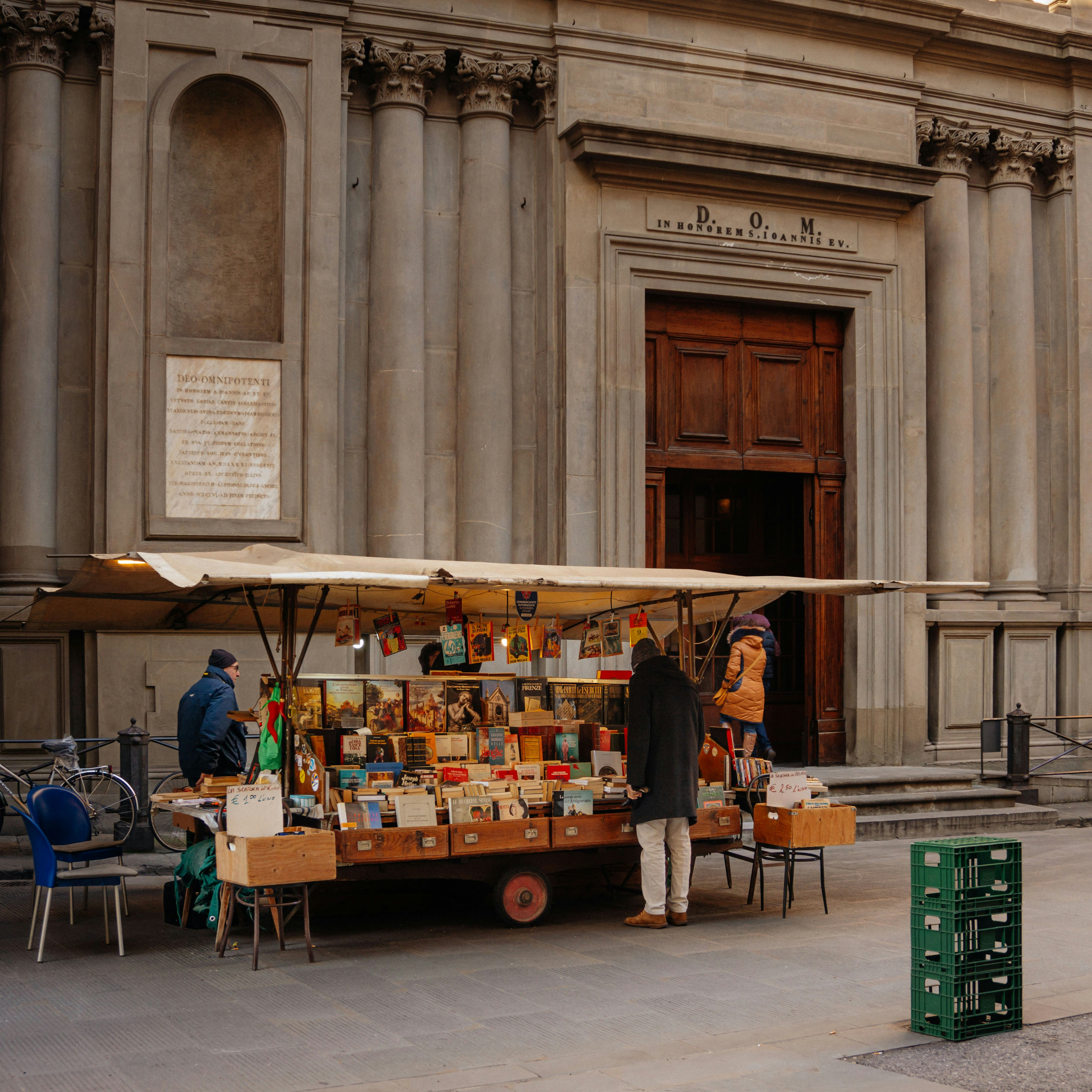 A man is standing in front of a cart selling items photo – Free People ...